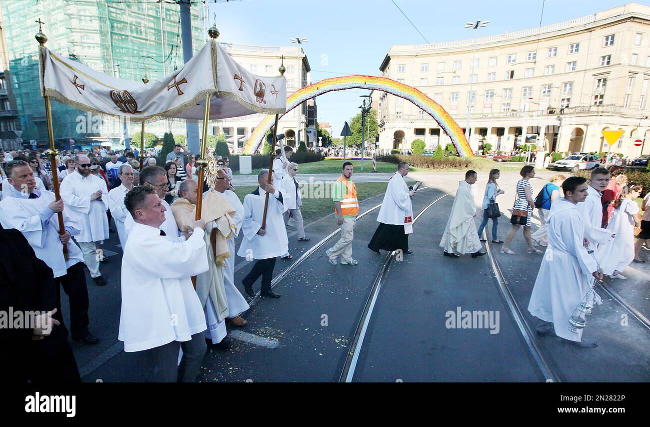 Participants walk in procession through the streets past a ...