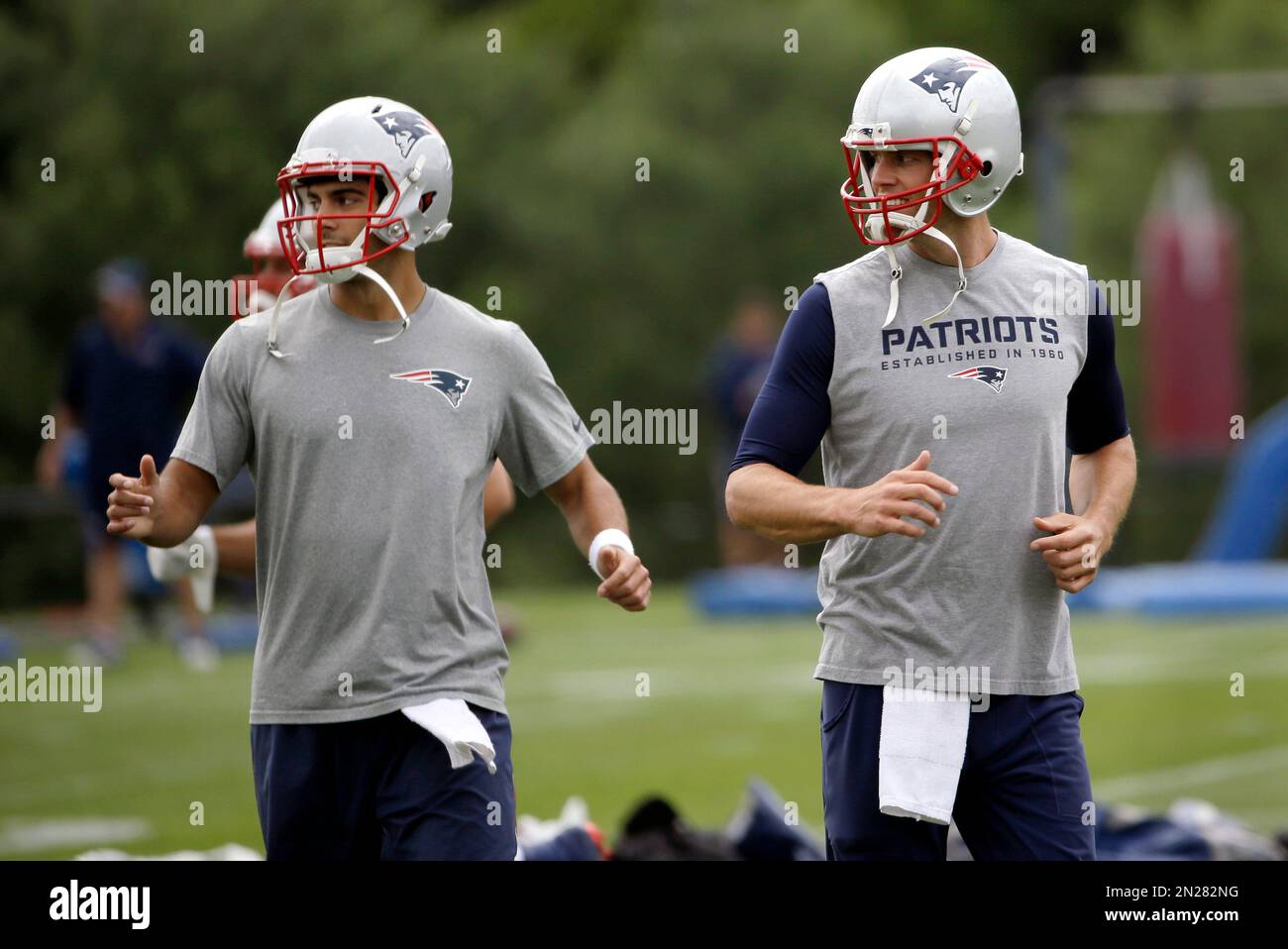 New England Patriots quarterback Tom Brady, right, runs with ...