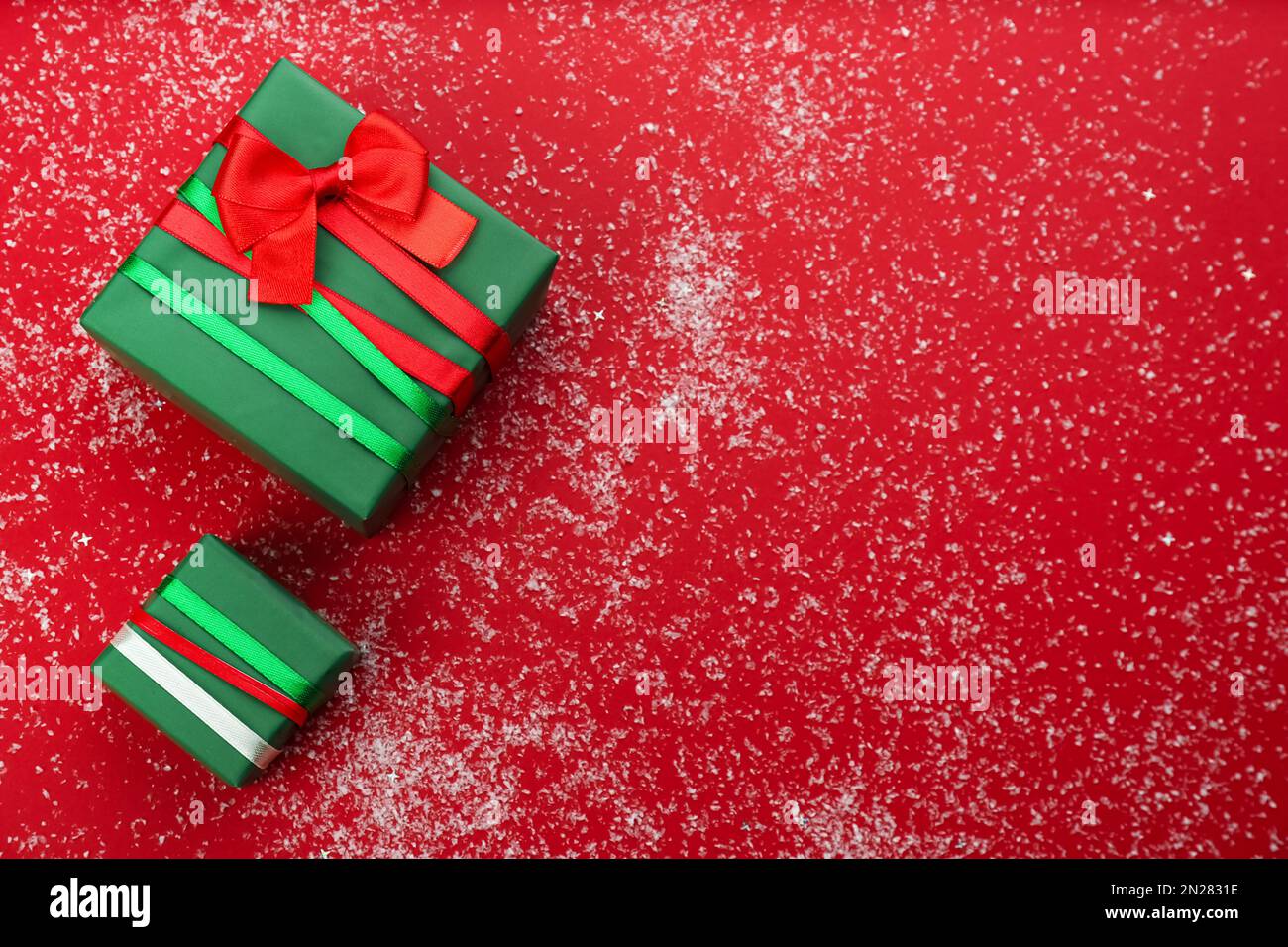 Christmas gift boxes with snow on red background, flat lay. Space for ...