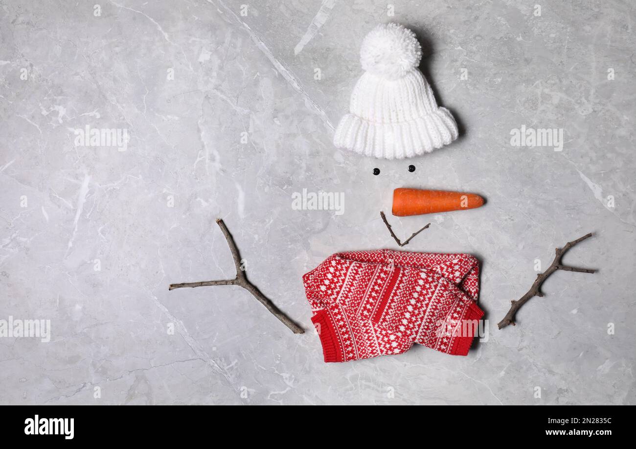 Funny snowman made with different elements on light grey marble ...