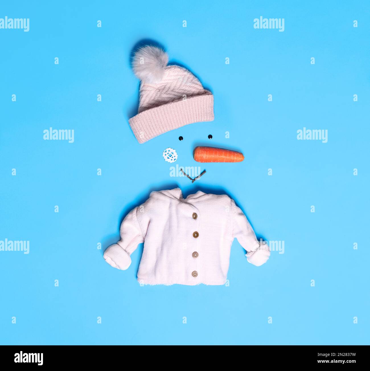Creative snowman shape made of different items on light blue background ...