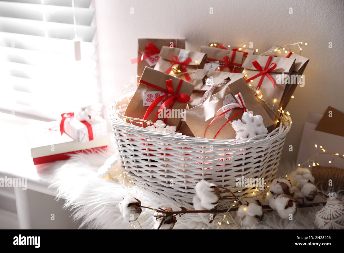 Set of gifts in basket and Christmas decor on window sill indoors ...
