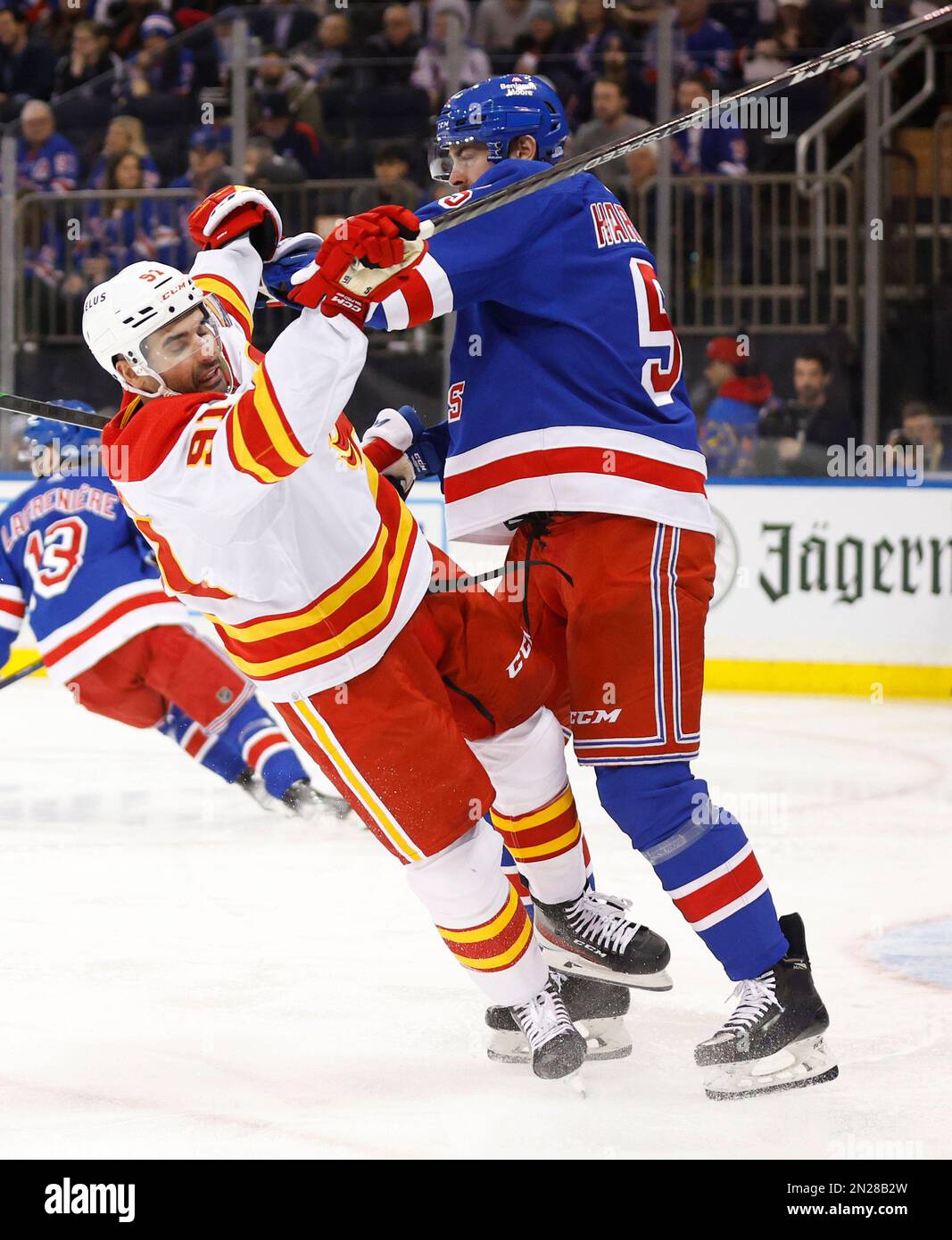 New York Rangers defenseman Ben Harpur checks Calgary Flames center ...