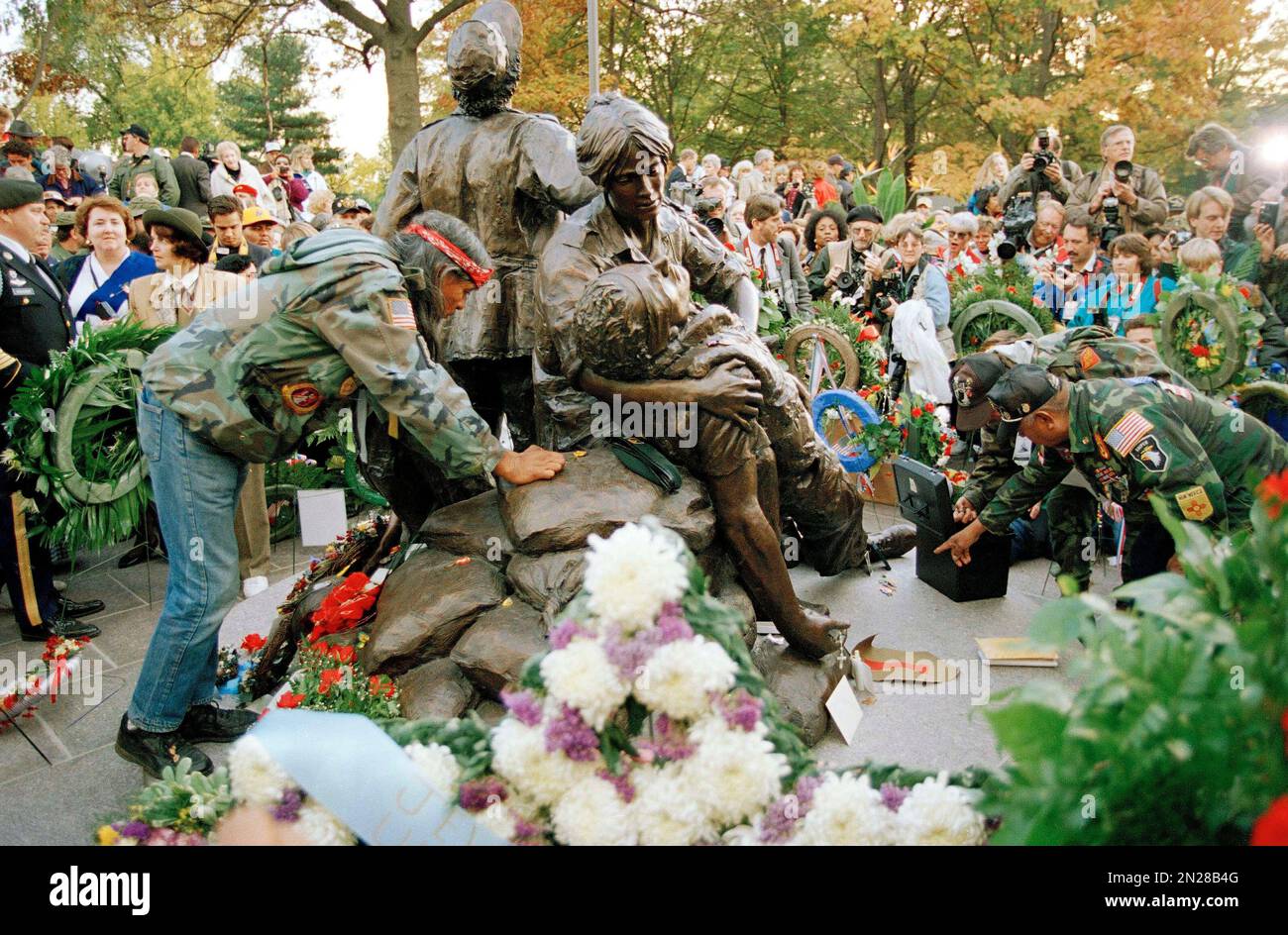 Vietnam veterans place mementos by the Vietnam Women's Memorial during ...