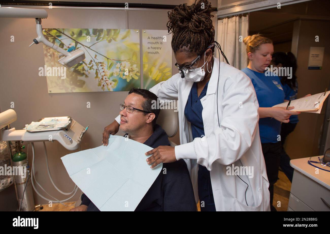 Dr. Jasmin Henville, center, prepares patient Moises Baez for an exam ...
