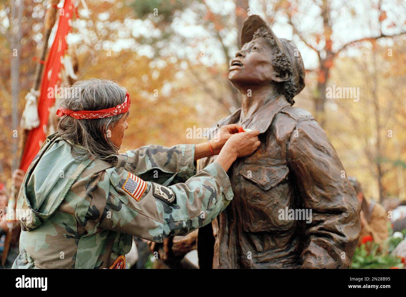 A Vietnam veteran places a medal on the Vietnam Women's Memorial during ...