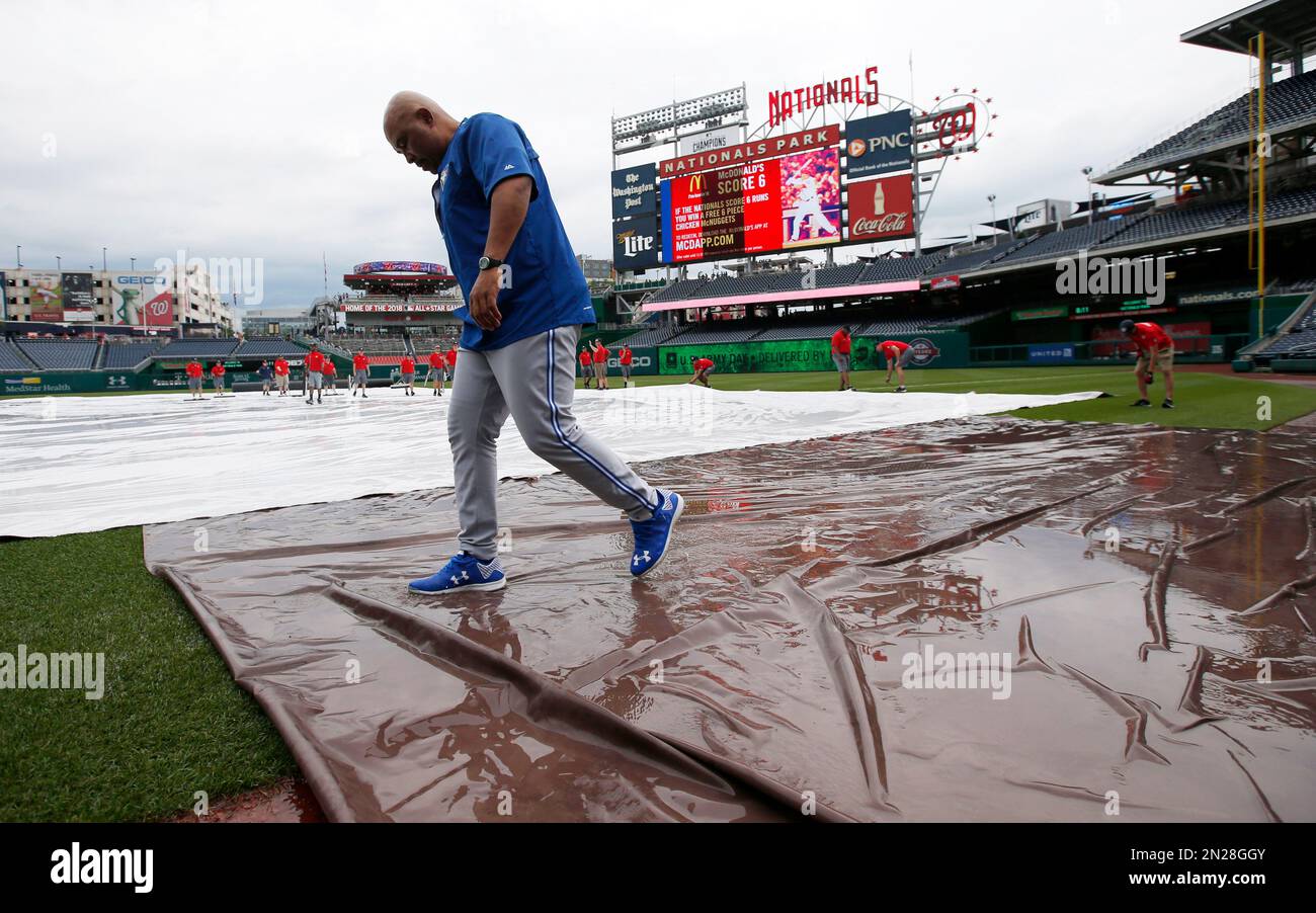 Toronto Blue Jays bench coach DeMarlo Hale walks over a water soaked ...