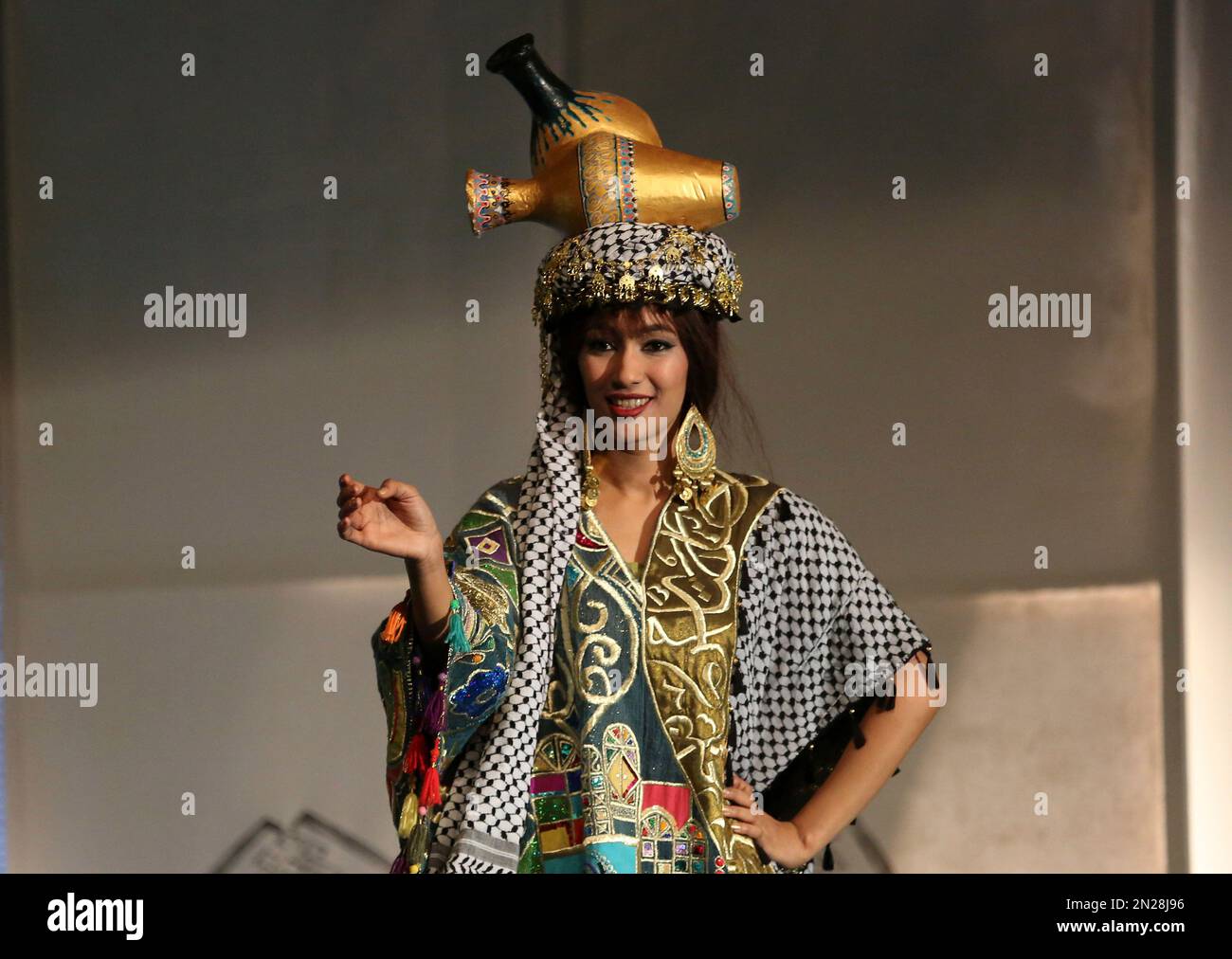 A model wearing a traditional Iraqi folk costume dances during the ...