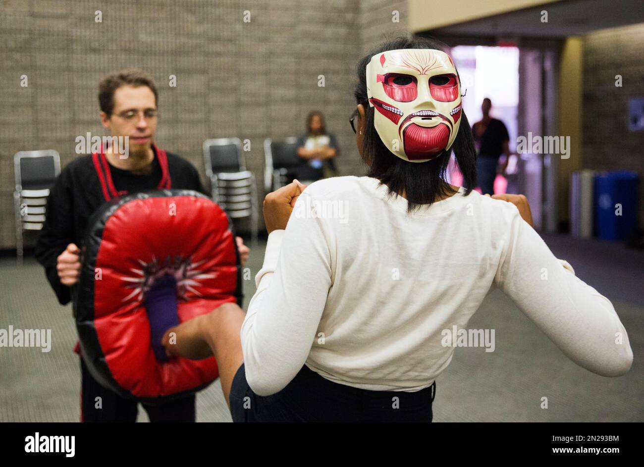 Carla Bates, wearing a Colossal Titan mask, practices a karate kick on ...