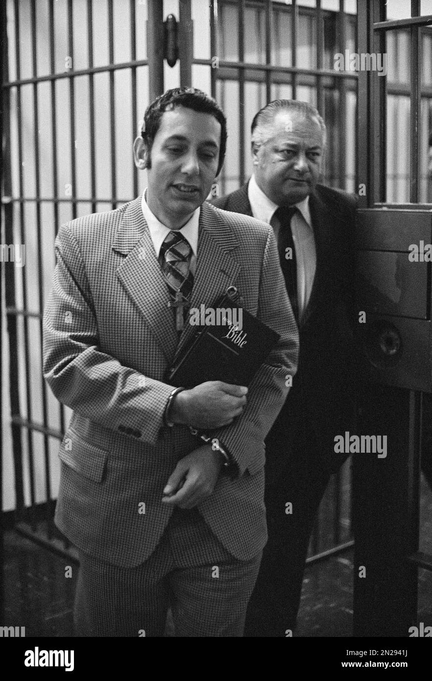 Joseph Kallinger of Philadelphia, his handcuffed wrists carrying a ...
