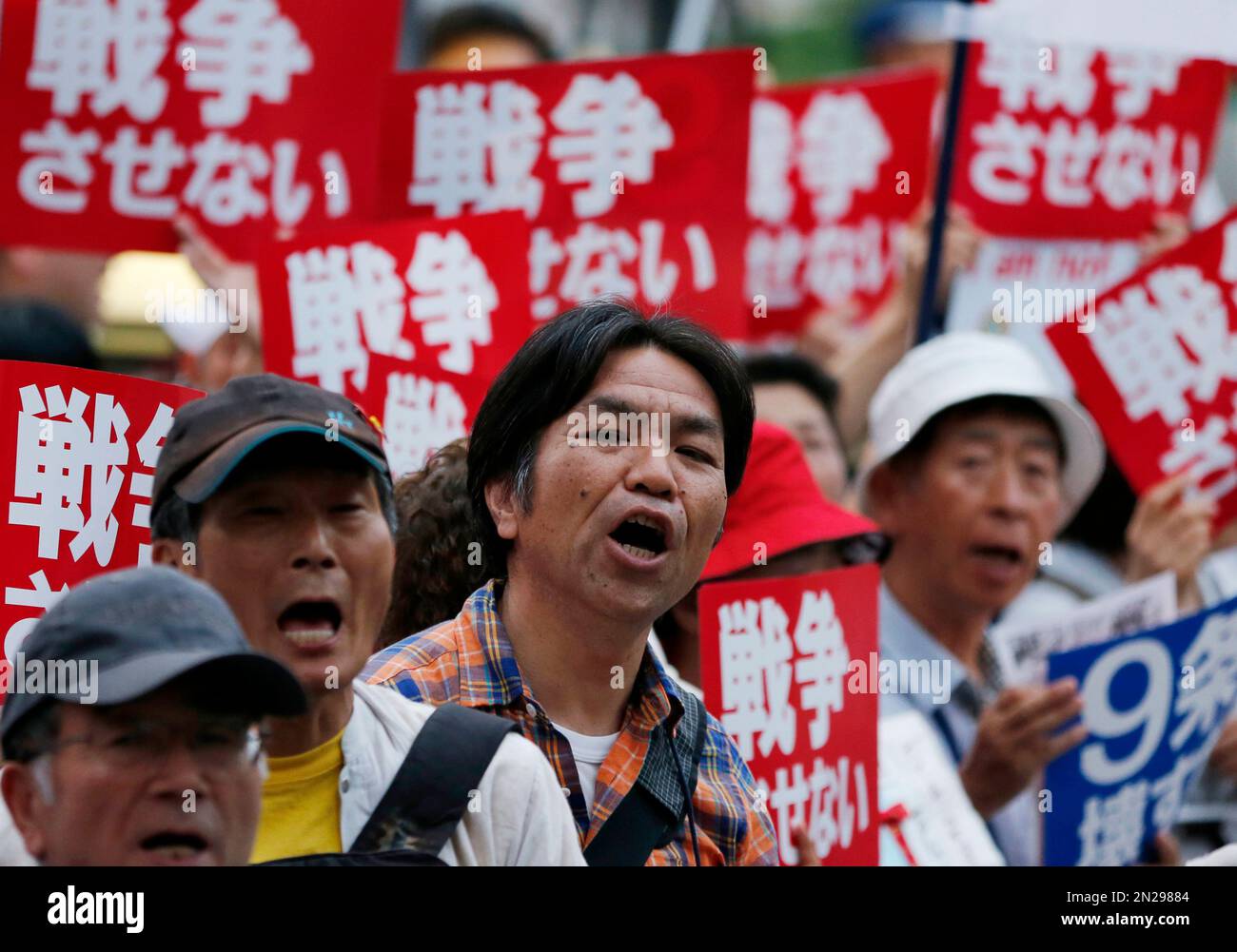 People stage a rally outside parliament in Tokyo, Thursday, May 28 ...