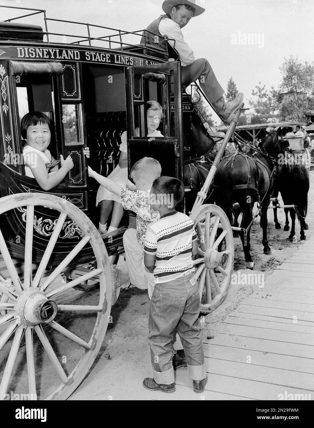 Children ride in an old-fashioned stagecoach in the Frontierland realm ...