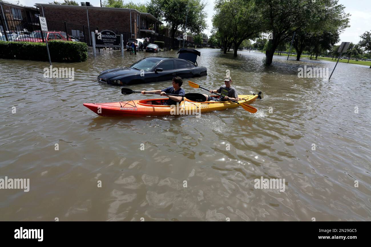 Lennie Blatt, left, and Mark Maaskant paddle down a flooded street in ...