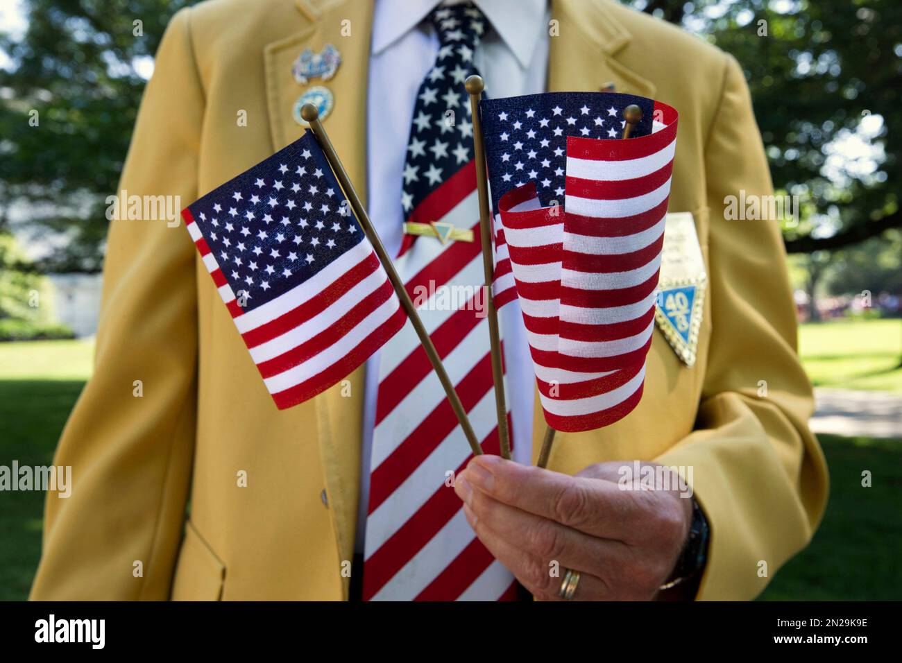 Navy veteran William Englert passes out U.S. flags to the crowd ...