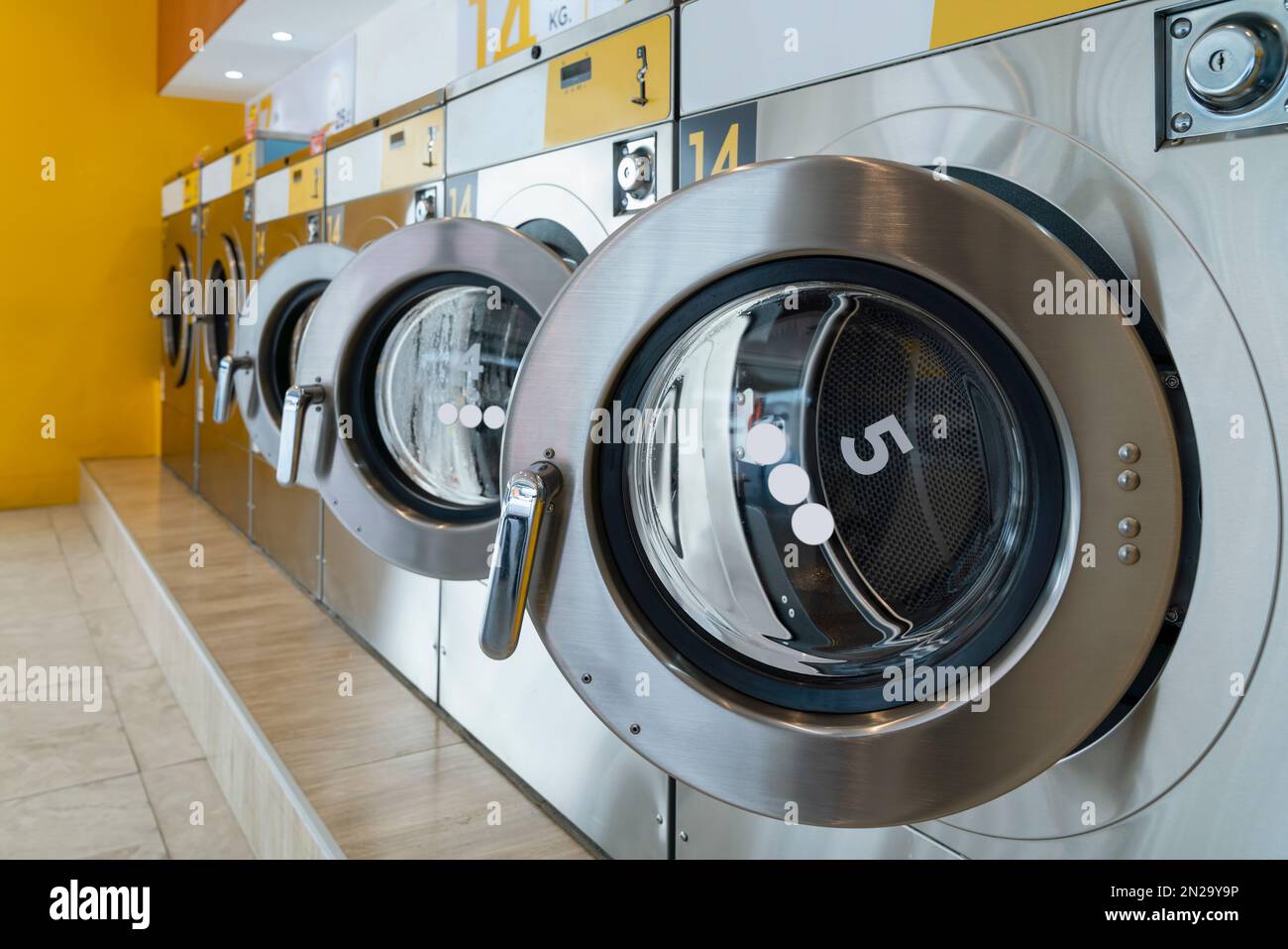 A row of qualified coin-operated washing machines in a public store ...