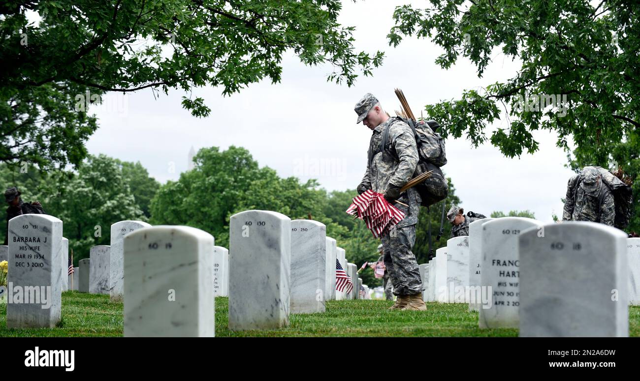 Members of the Old Guard place a flag in front of each headstone at ...