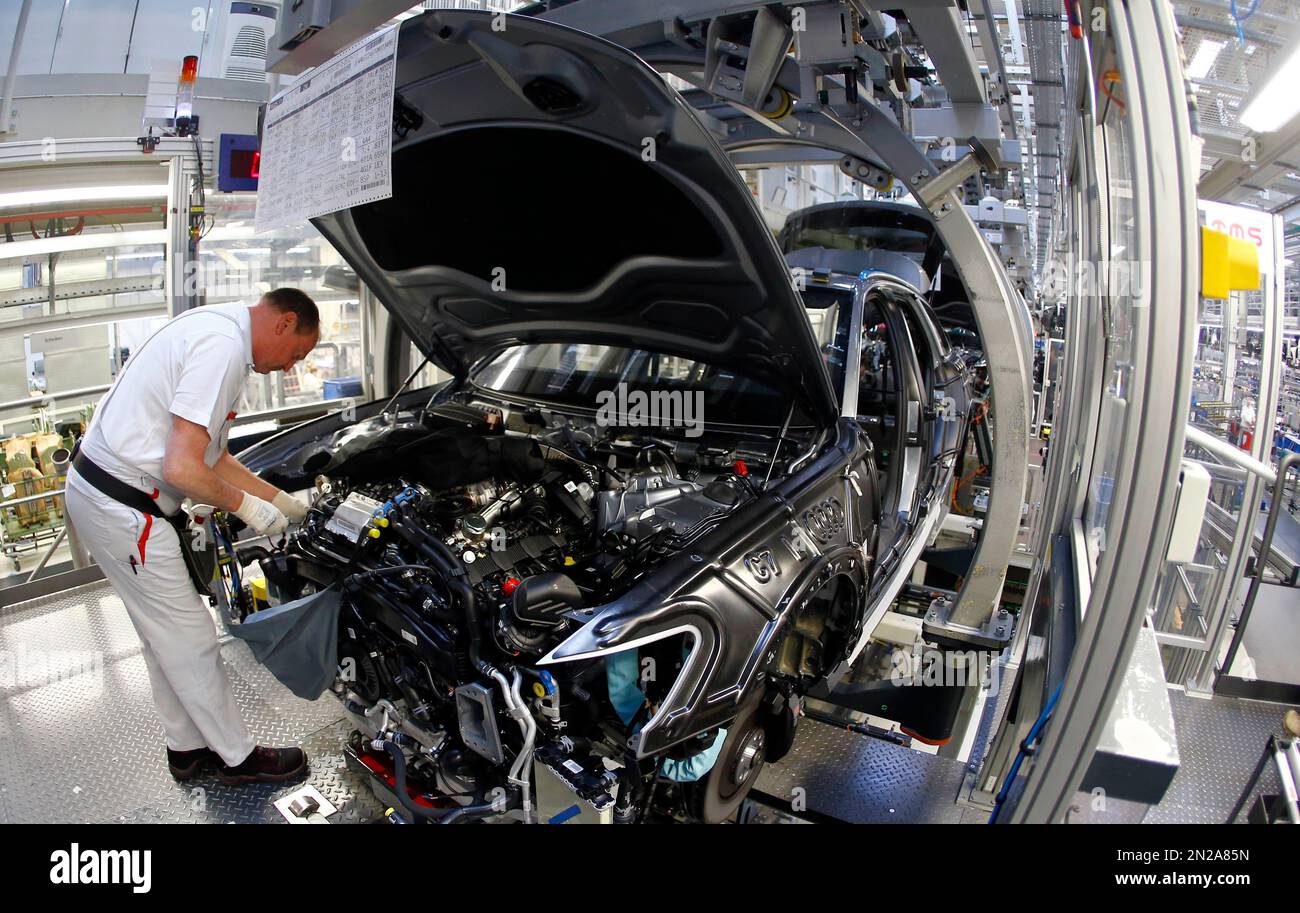 An employee of German car producer Audi works in the assembly line of ...