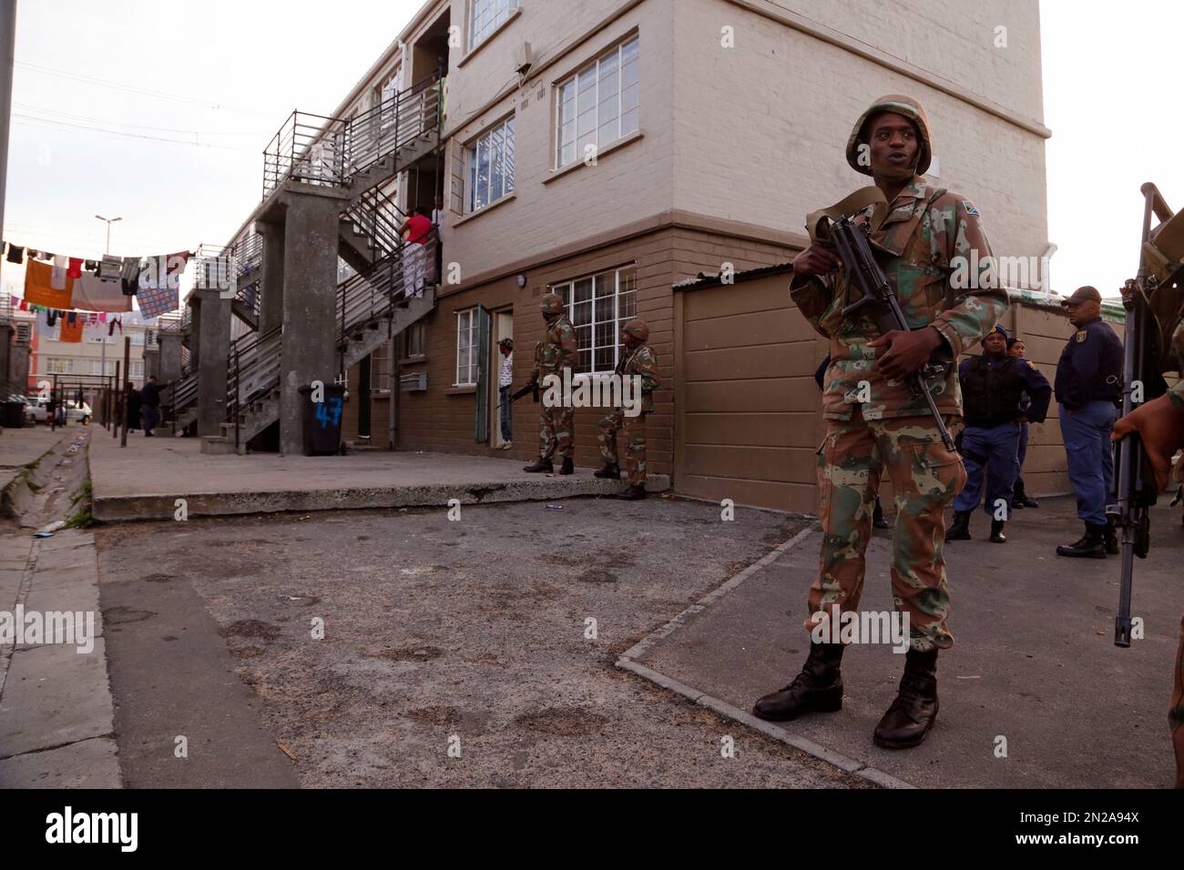 A soldier provide security for policemen during a raid on an apartment ...
