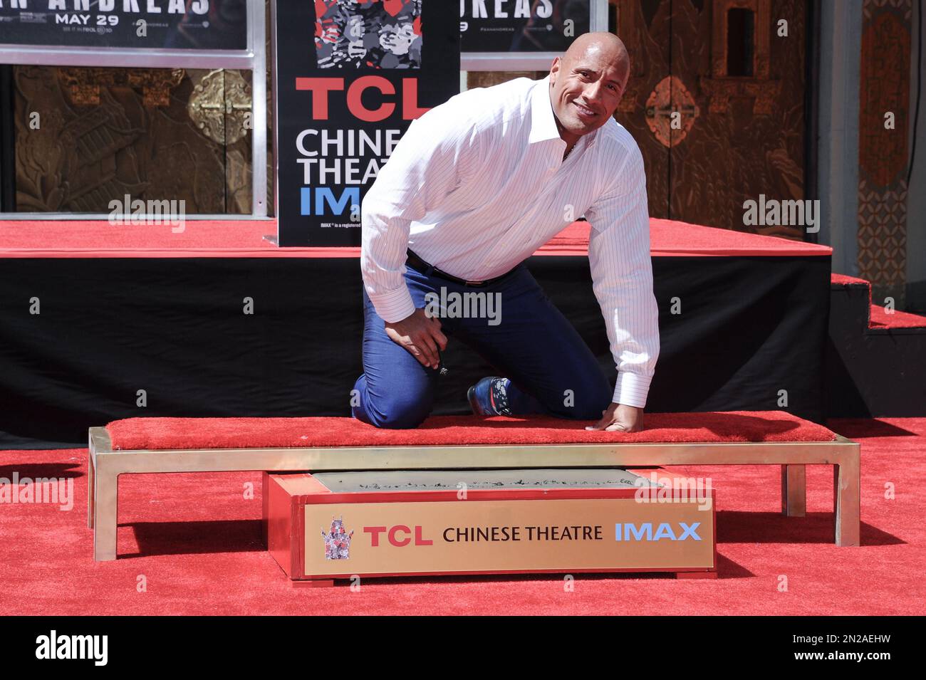 Dwayne Johnson signs his name in wet cement at his Hand And Footprint ...