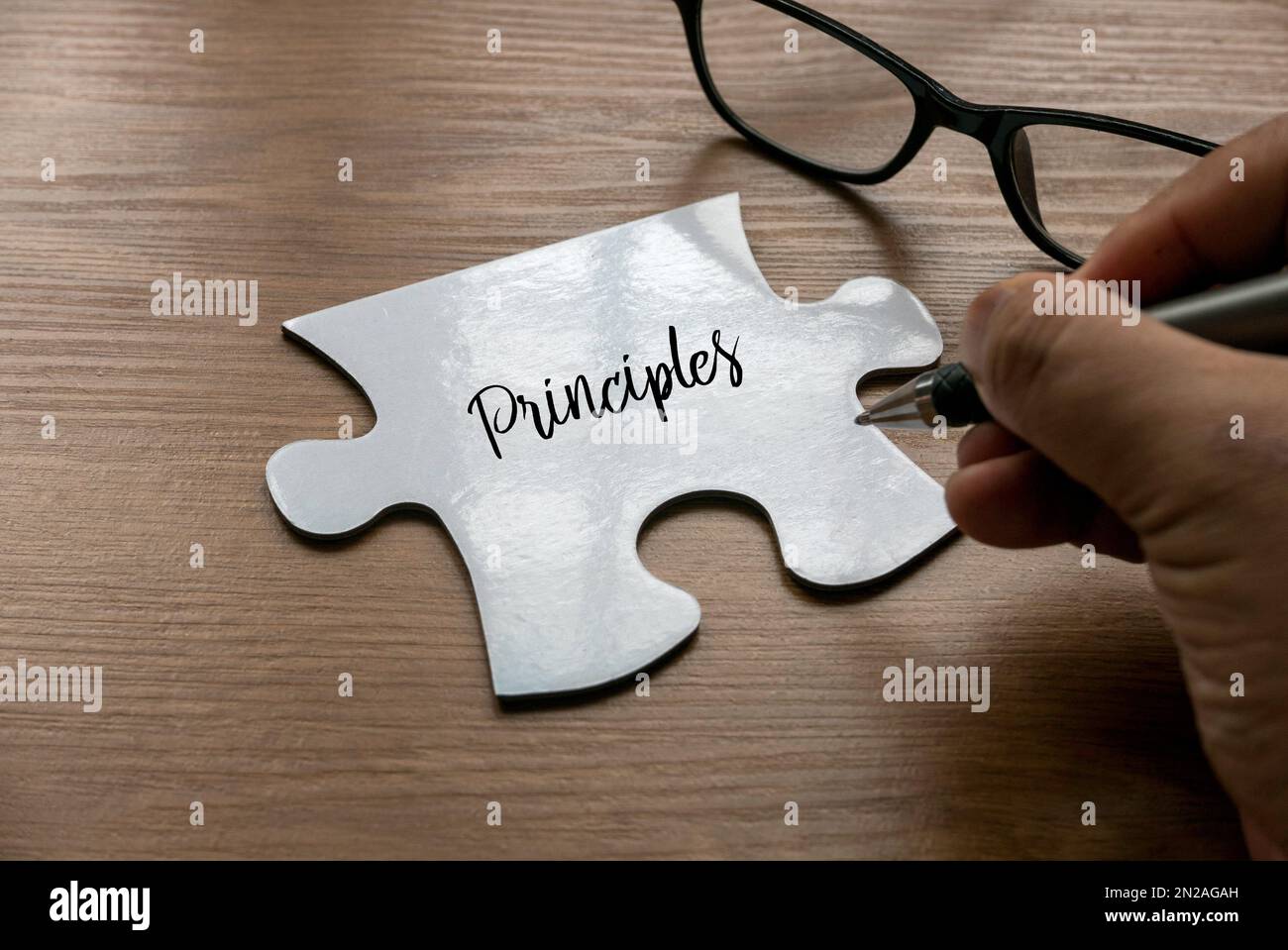 Selective focus of a hand writing word ' Principles ' on a a piece of ...