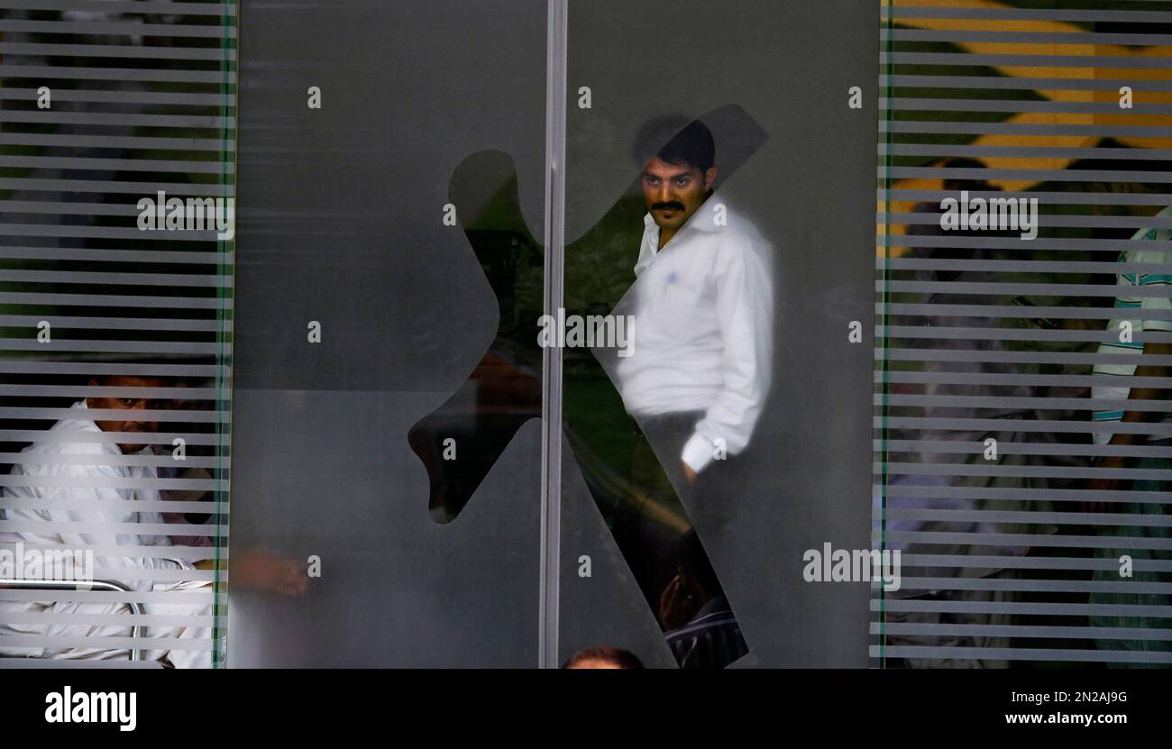 A plainclothes officer of Pakistan's Federal Investigation Agency peers ...