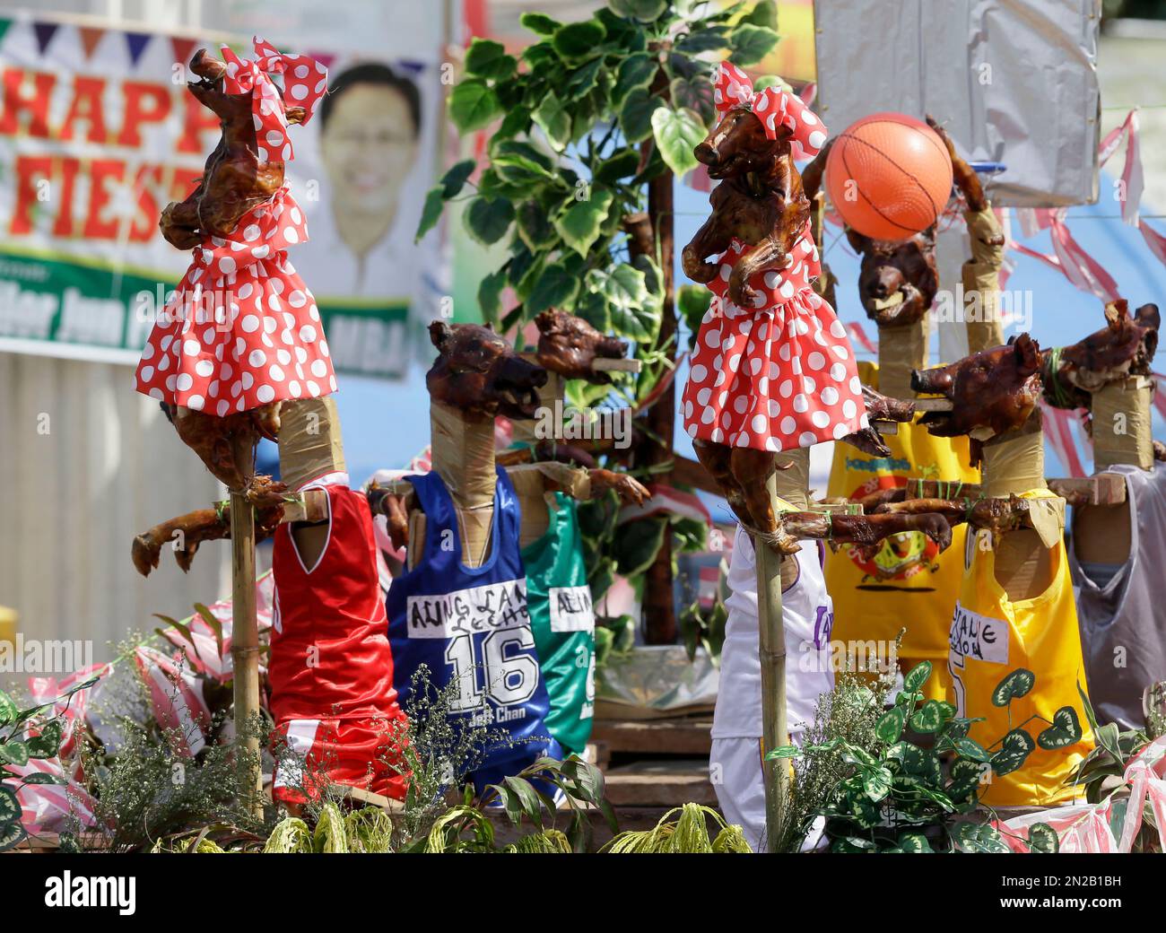 A float with roast pigs wearing basketball jerseys is paraded through ...