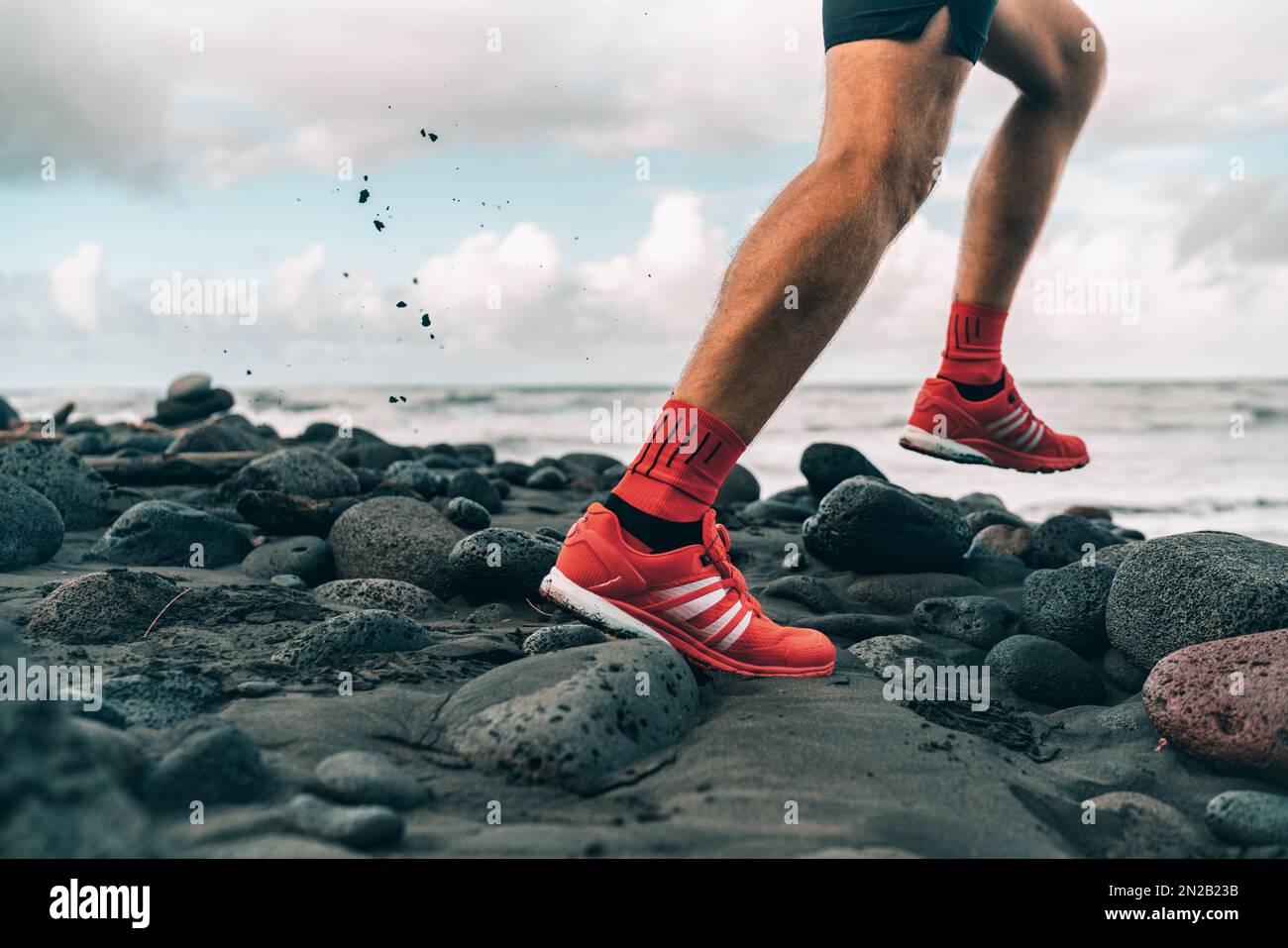 Running shoes of athlete man jogging on beach. Difficult terrain with ...