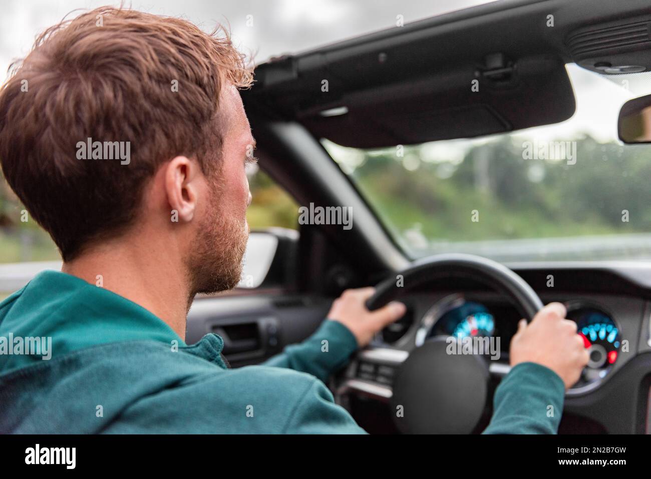 Road trip drive man driver driving open roof convertible sports car on summer travel holiday ...