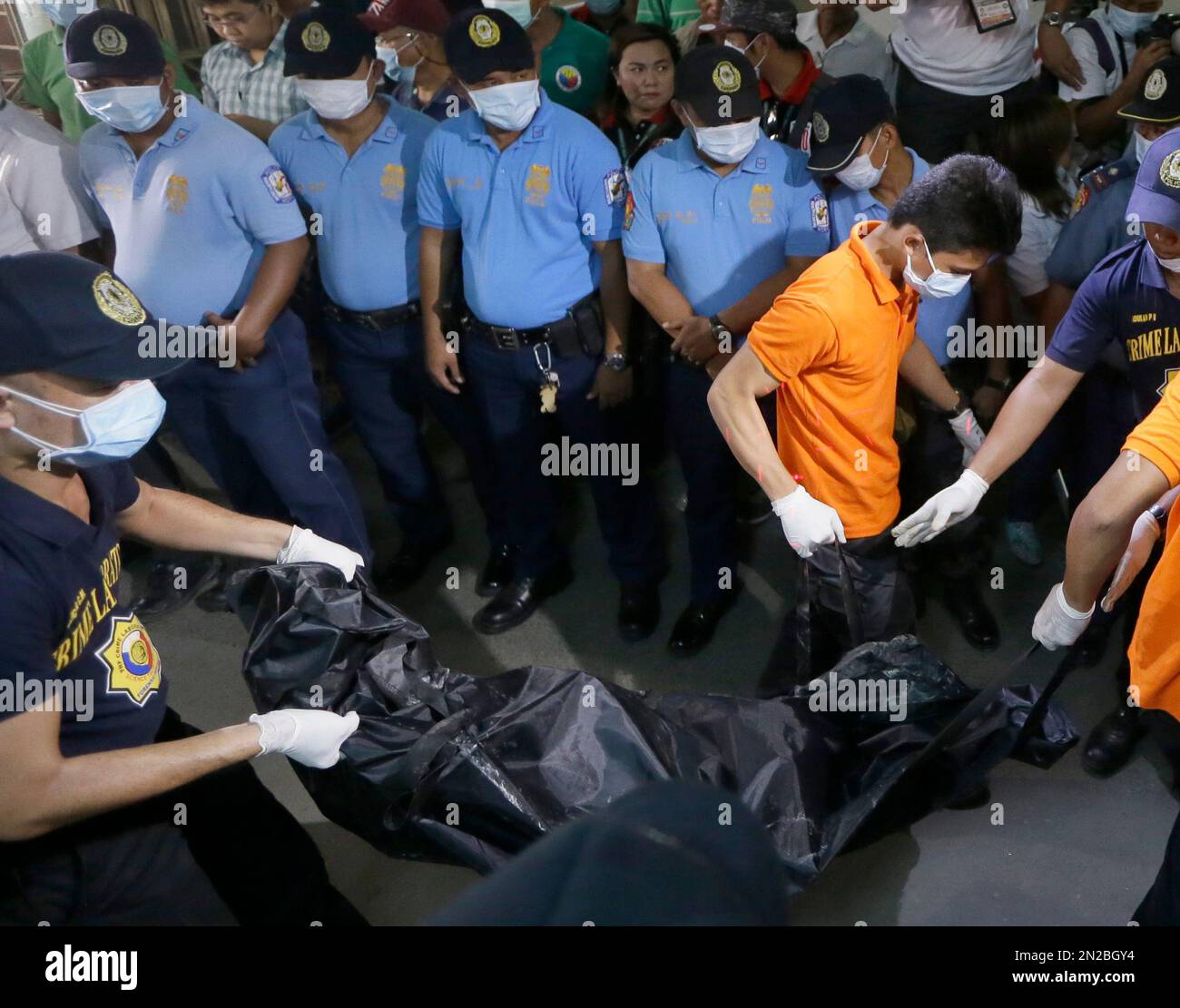 Philippine National Police carry a body bag containing the remains of ...