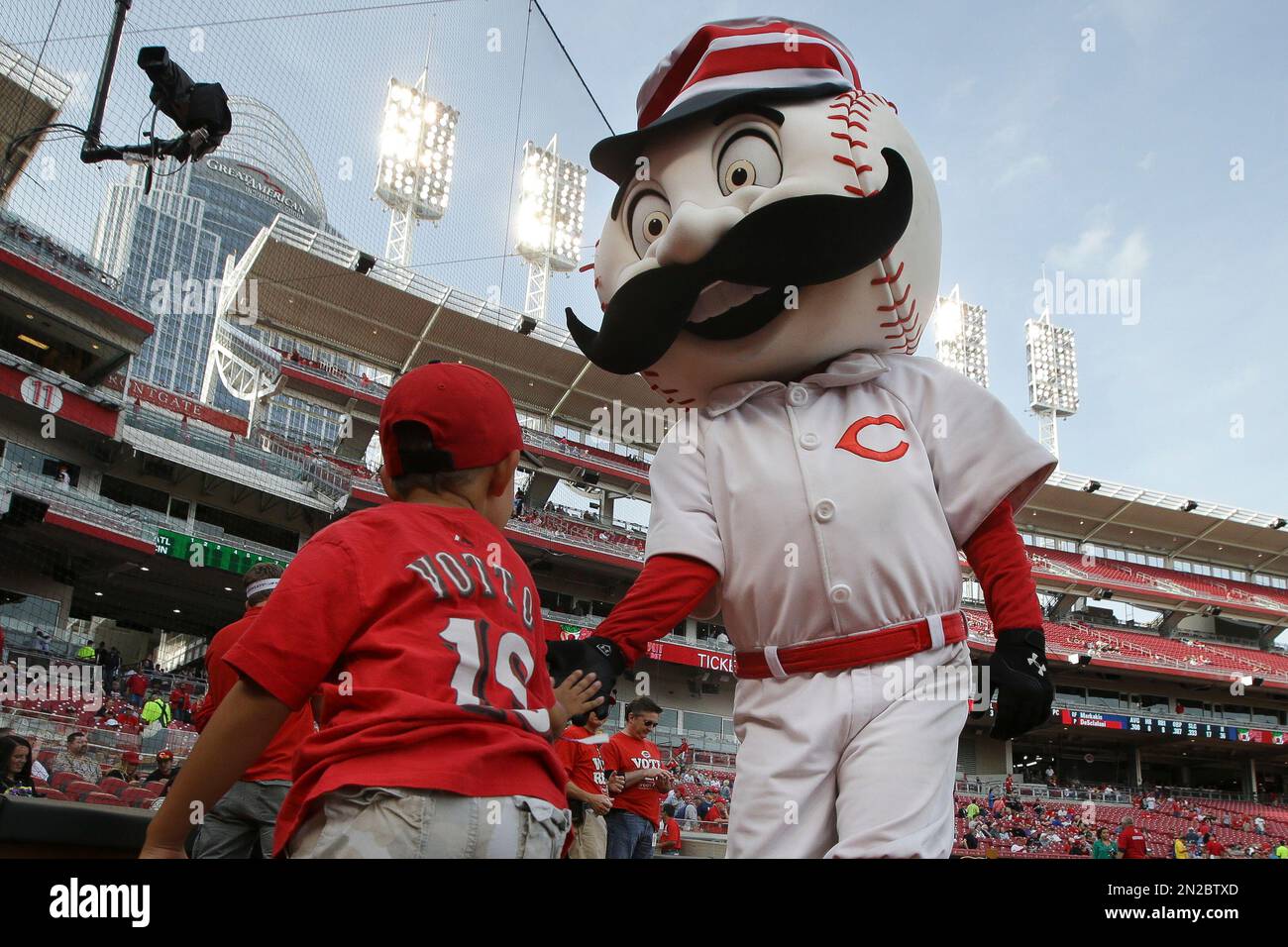 Cincinnati Reds mascot Mr. Redlegs greets a young fan before a baseball ...