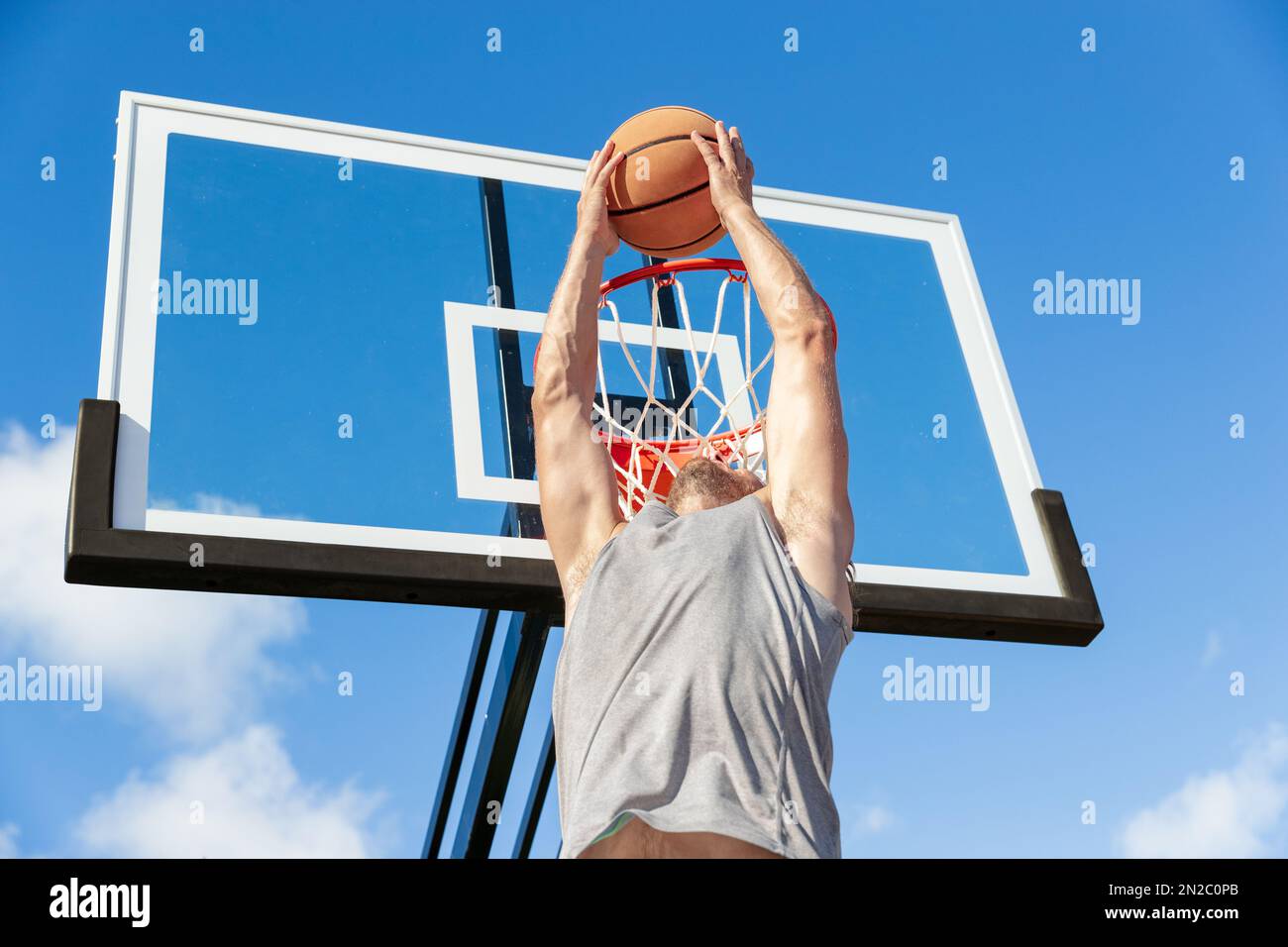 Basketball slam dunk man jumping to hoop throwing ball Stock Photo - Alamy