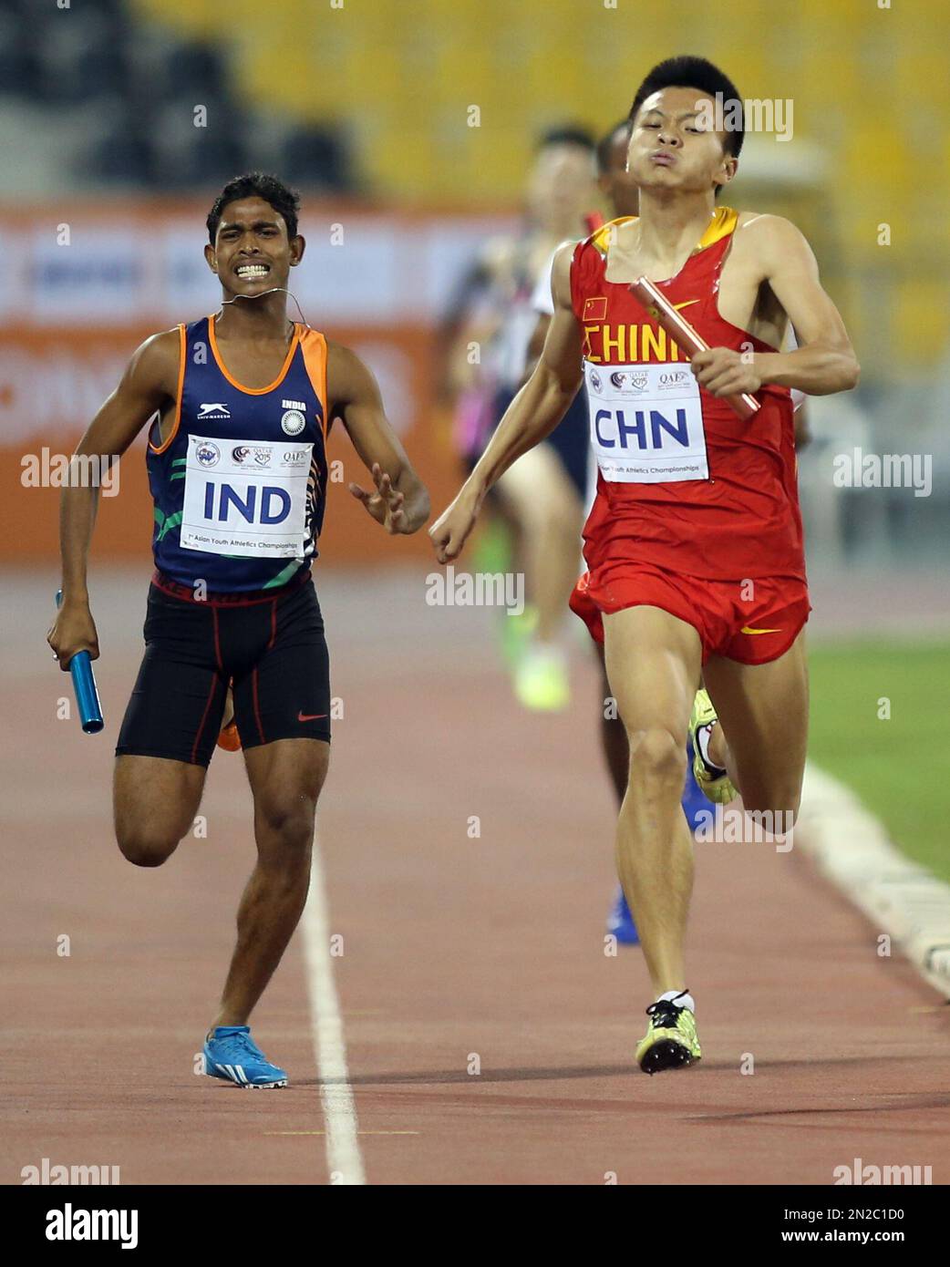 Wu Yu Ang of China, right, runs to win a men's 4x400m race at the Asian ...