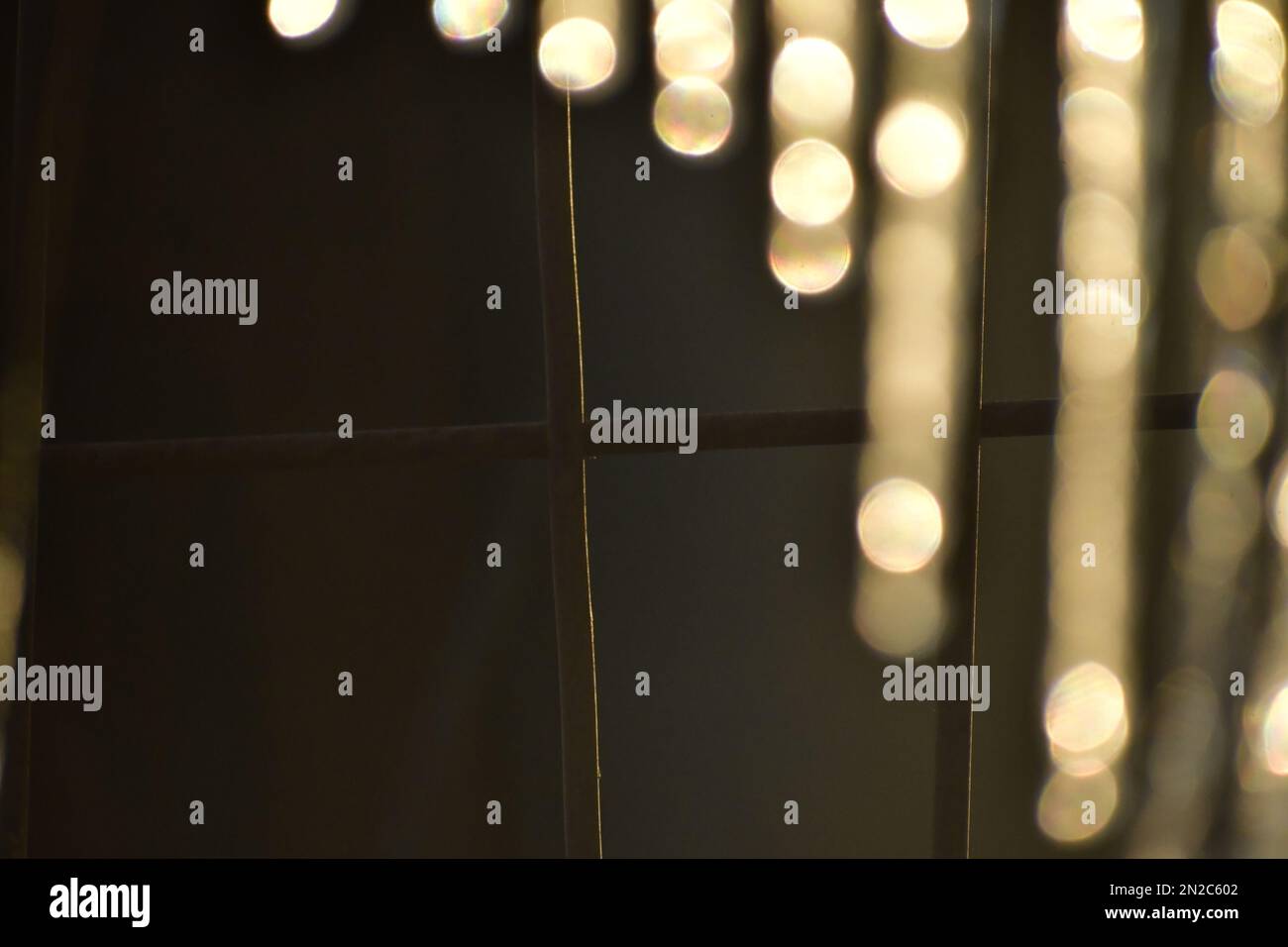 Sun rays in the background of a metal gate with icicles Stock Photo - Alamy