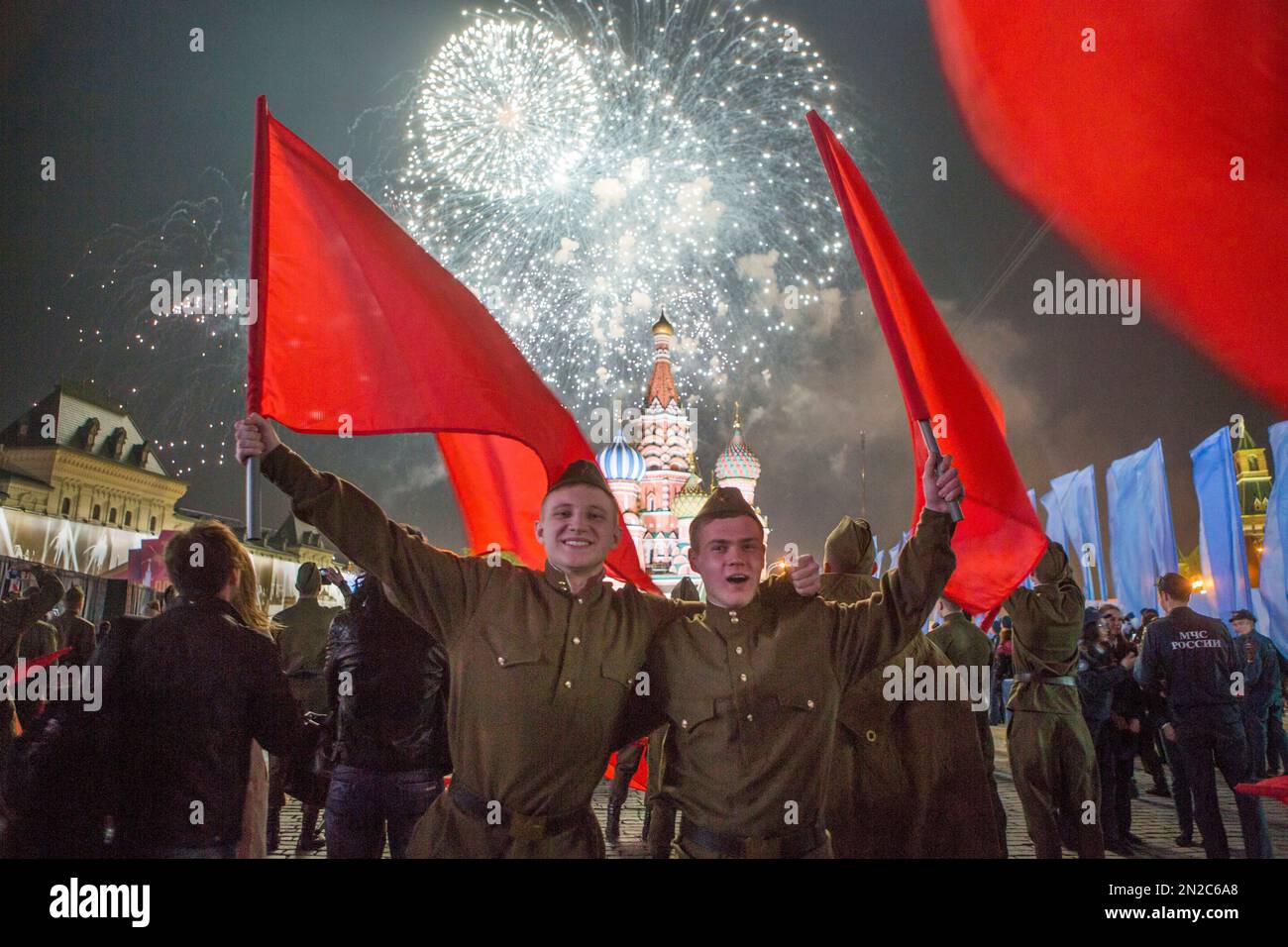 Actors dressed in WWII Soviet era uniform wave red flags while ...