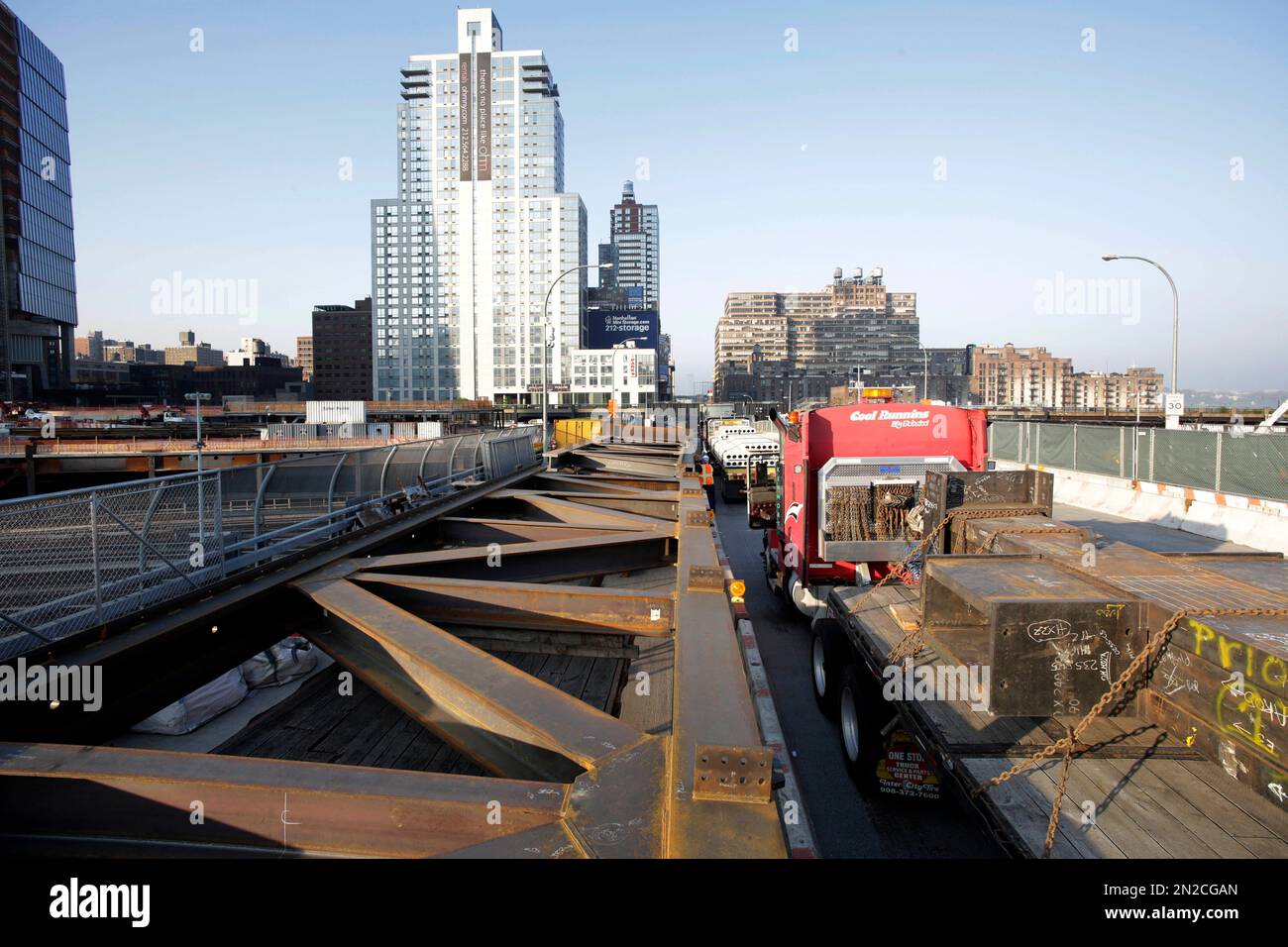 Massive steel structural pieces arrive on flatbed trucks for delivery ...