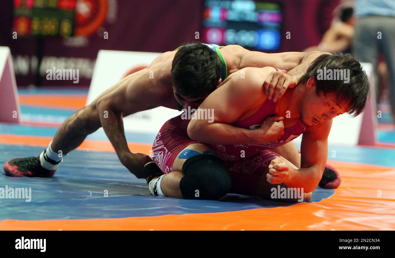 Japanese wrestler Takafumi Kojima, right, wrestles Uzbek wrestler ...