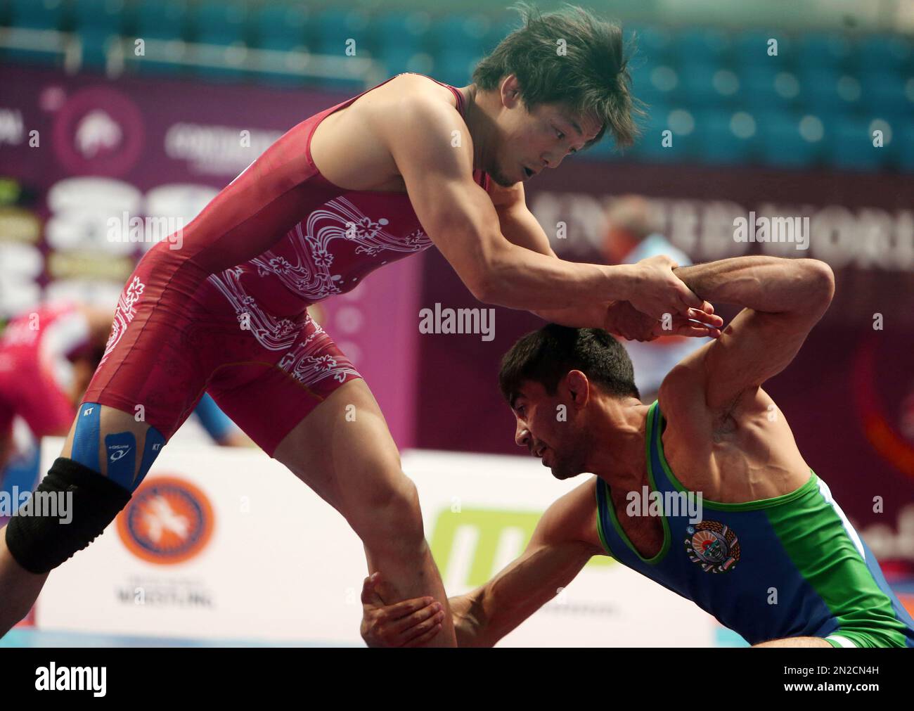 Japanese wrestler Takafumi Kojima, left, wrestles Uzbek wrestler Bekzod ...