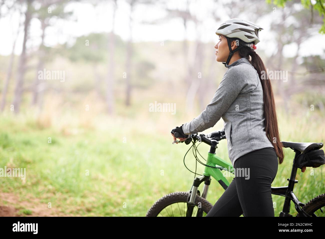 Focused on the road ahead. An attractive female cyclist walking ...