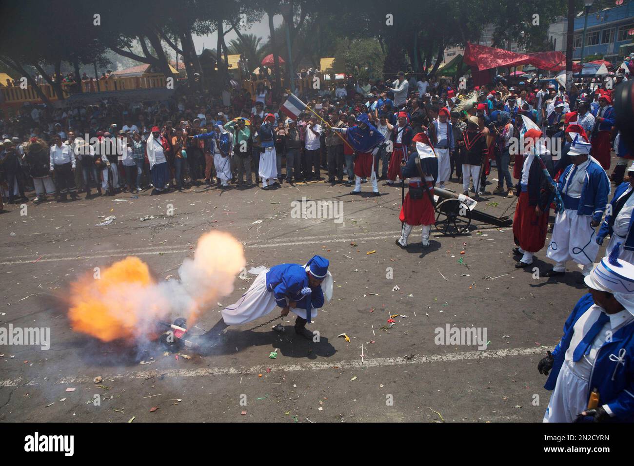 People look on as local residents dressed as French soldiers fire a ...