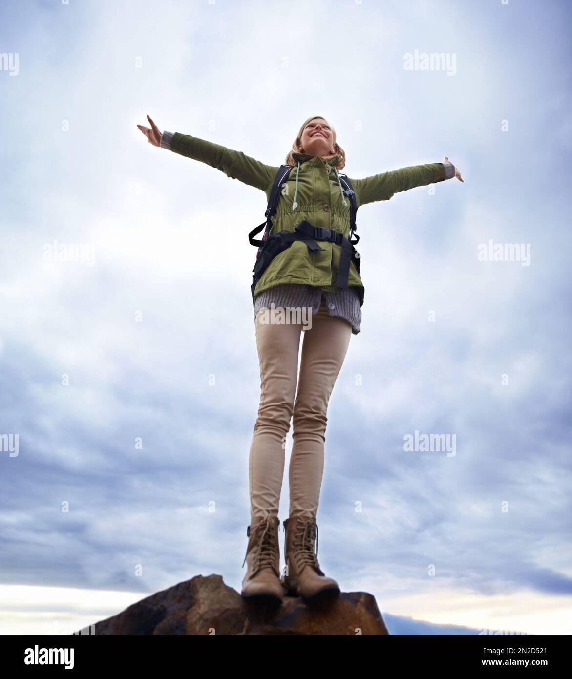In the spirit of adventure. A young woman standing with her arms ...
