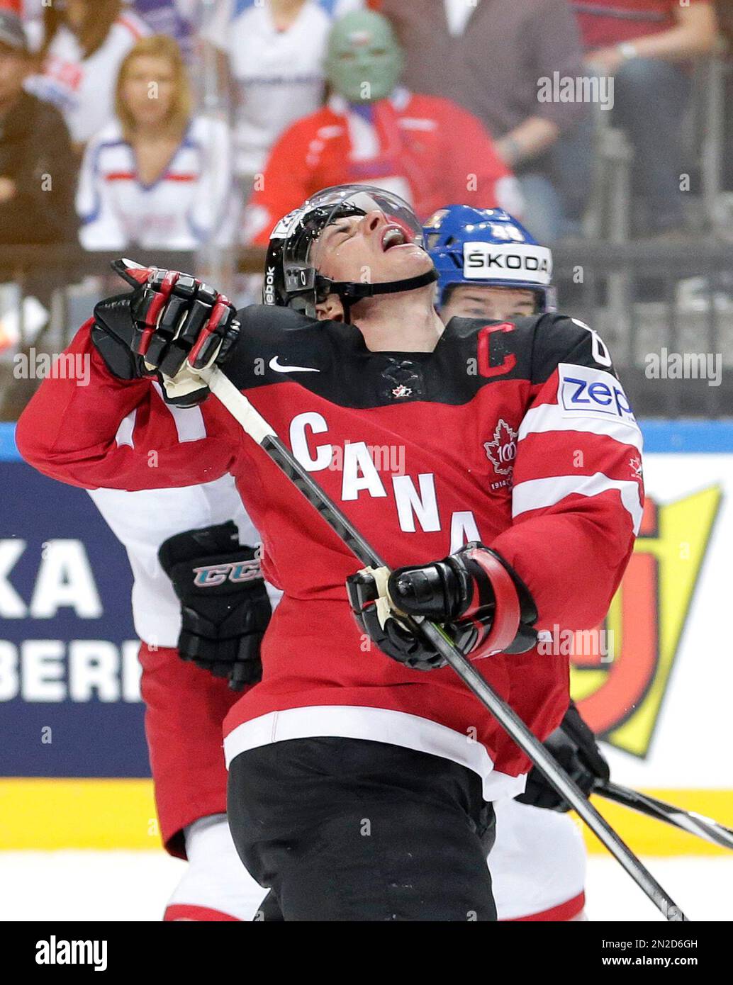 Canada’s Sidney Crosby grimaces in pain after being hit in the face by ...
