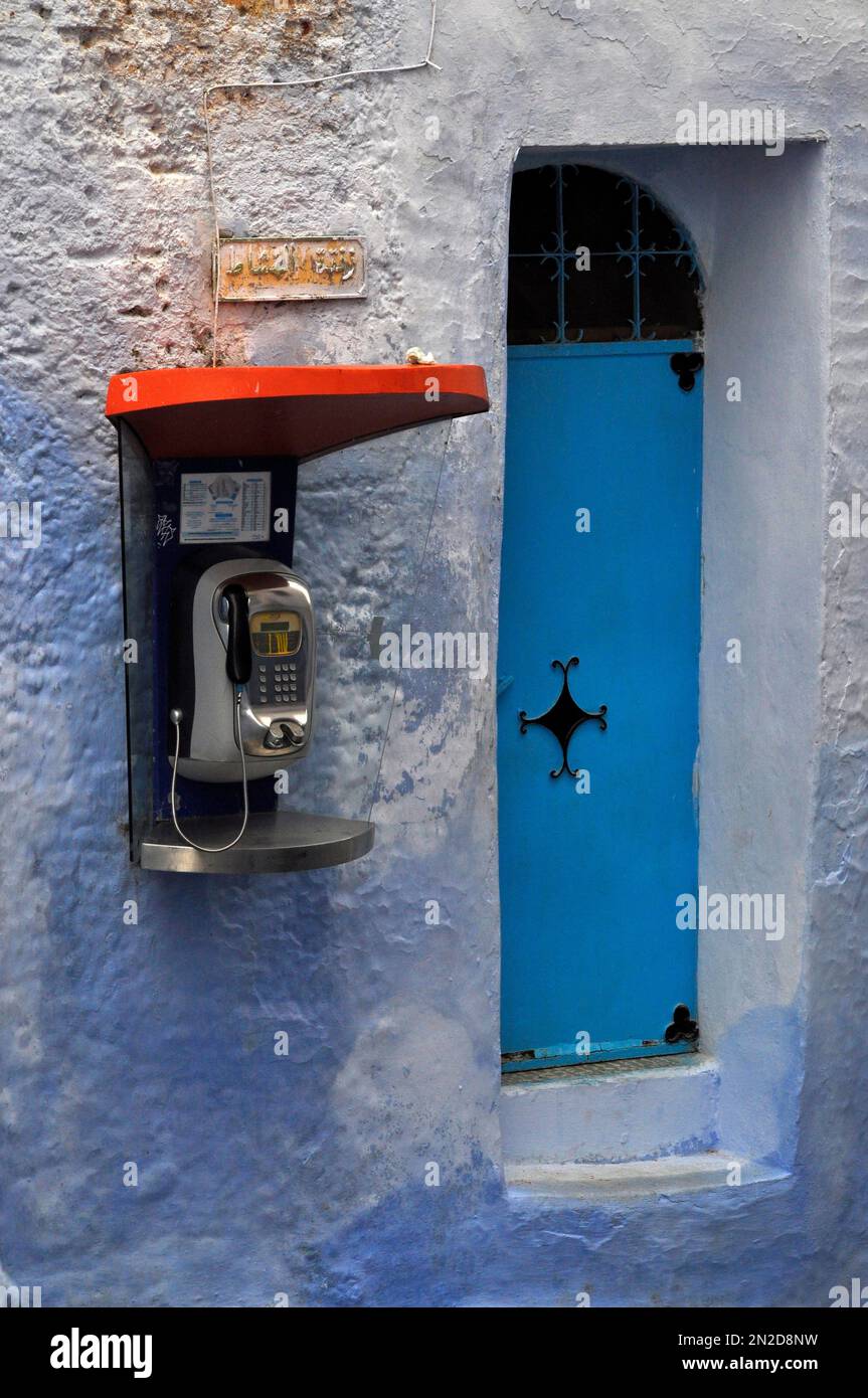 Modern public telephone next to blue door, Chefchaouen, Northern ...