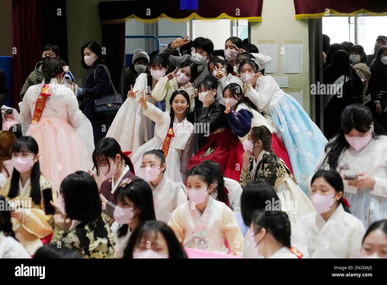 High school seniors clad in traditional attire pose for their souvenir ...