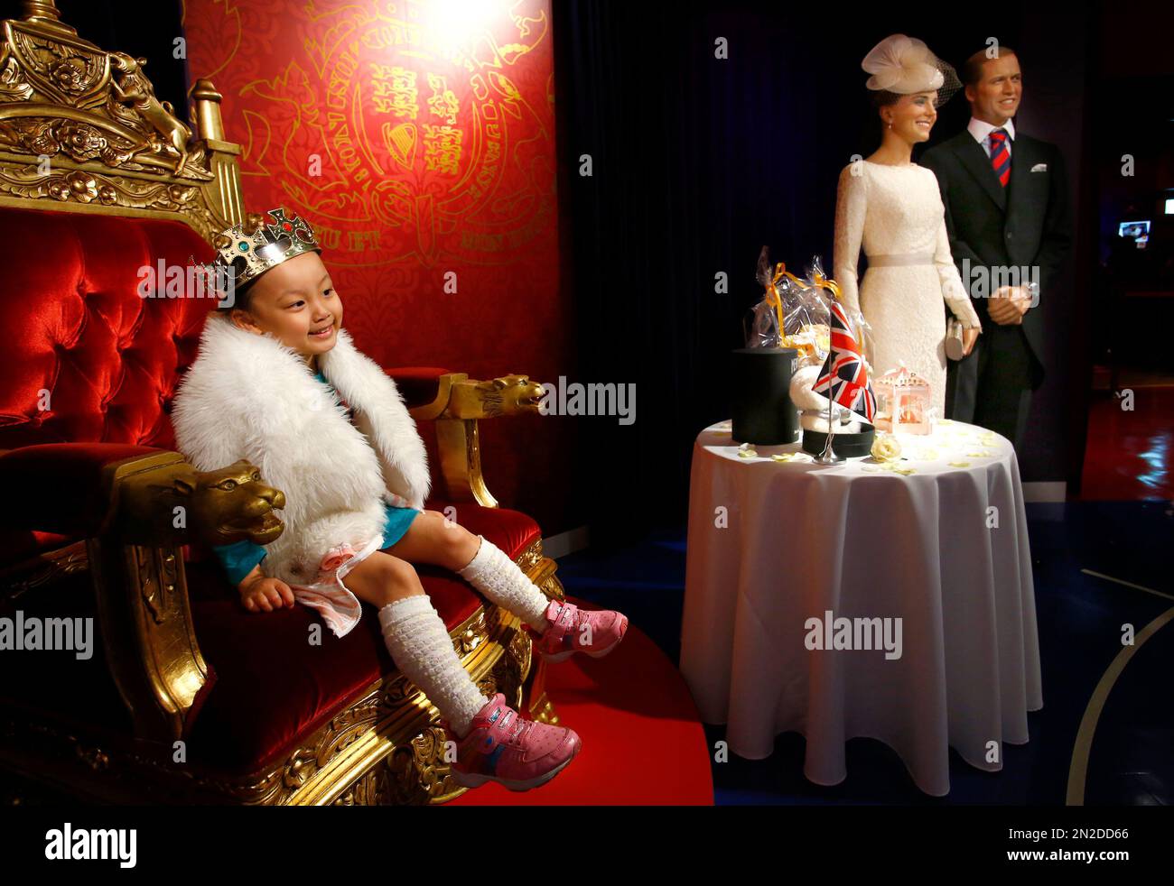 Kokoro Inao (4) poses for a picture with wax figures of Britain's ...