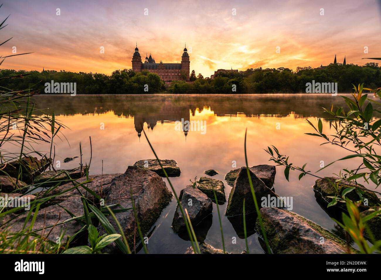 Johannisburg Castle reflected in the Main, riverbank, dawn twilight ...