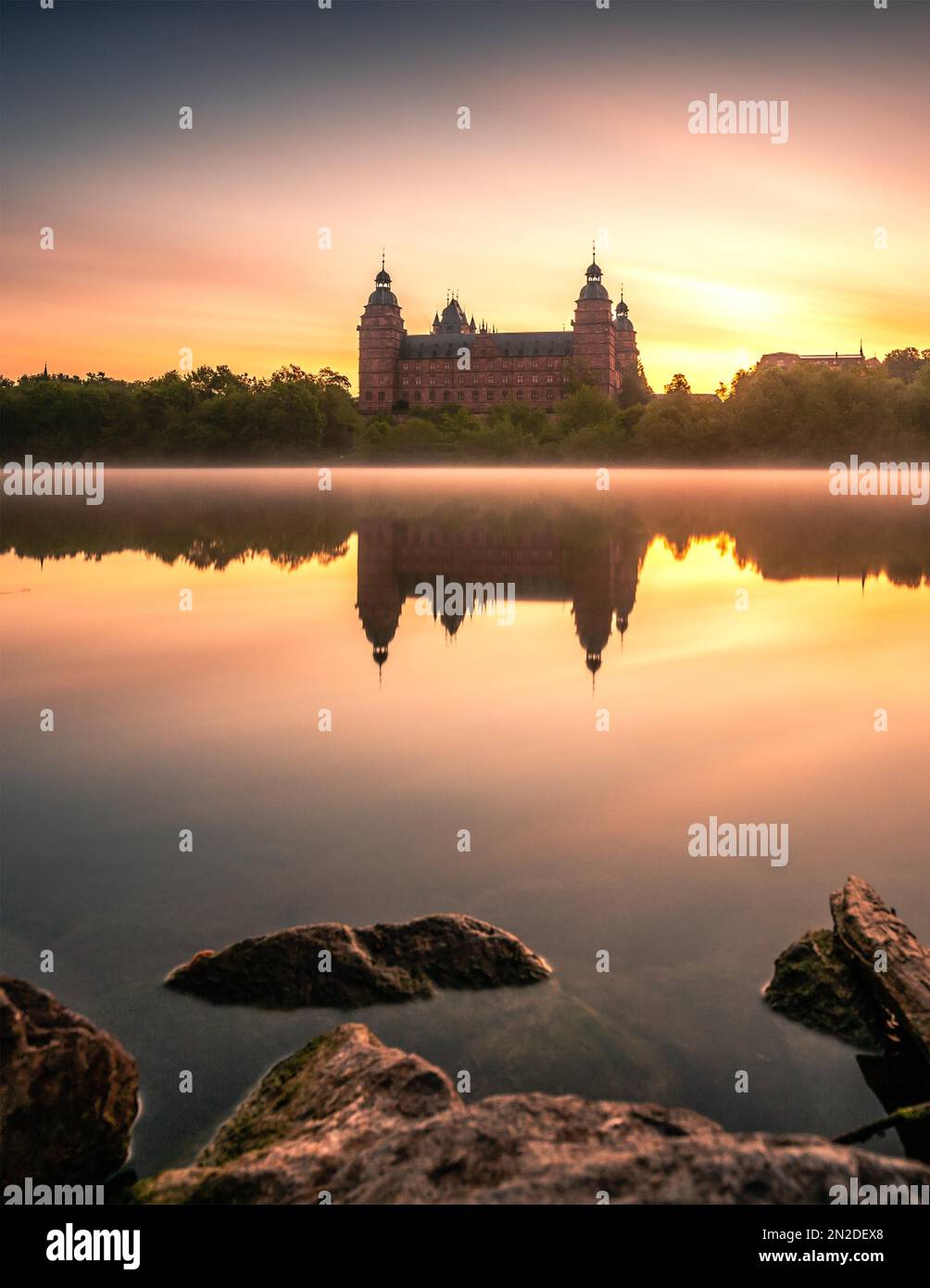 Johannisburg Castle reflected in the Main River, riverbank, dawn ...