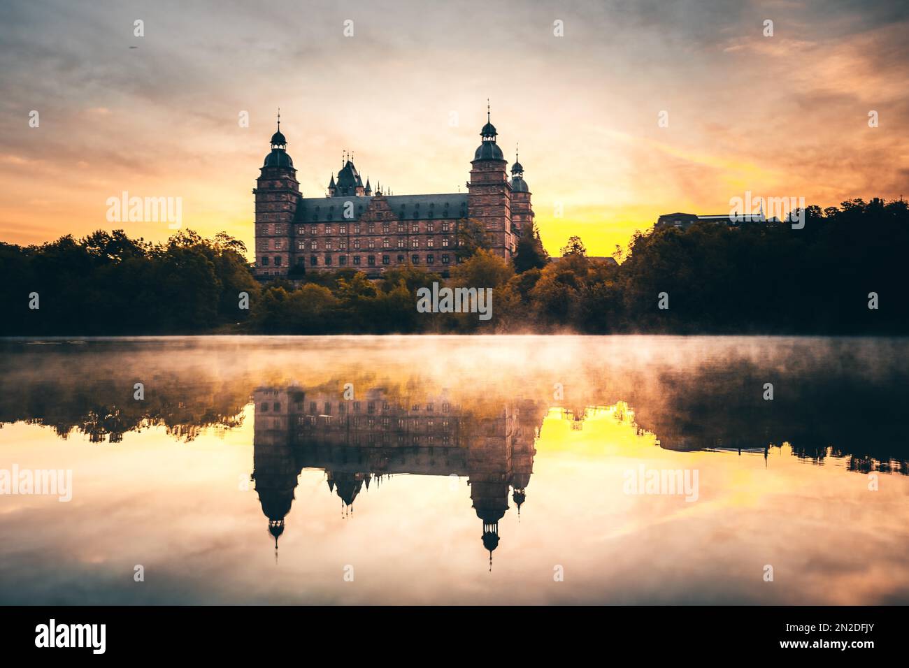 Johannisburg Castle reflected in the Main River, riverbank, dawn ...