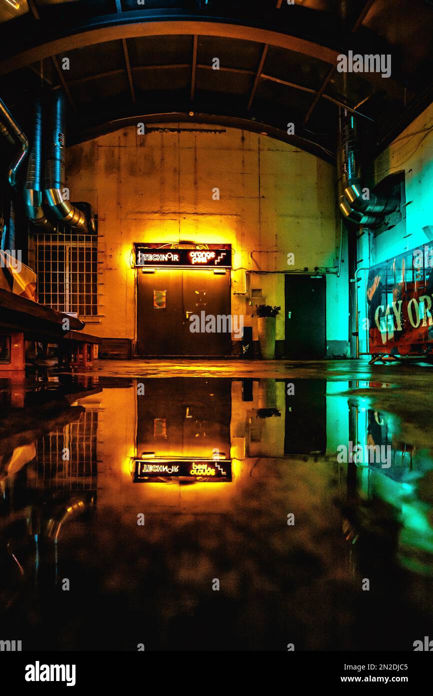 House entrance at night, illuminated passageway, with reflection on the floor. Hesse, Germany ...