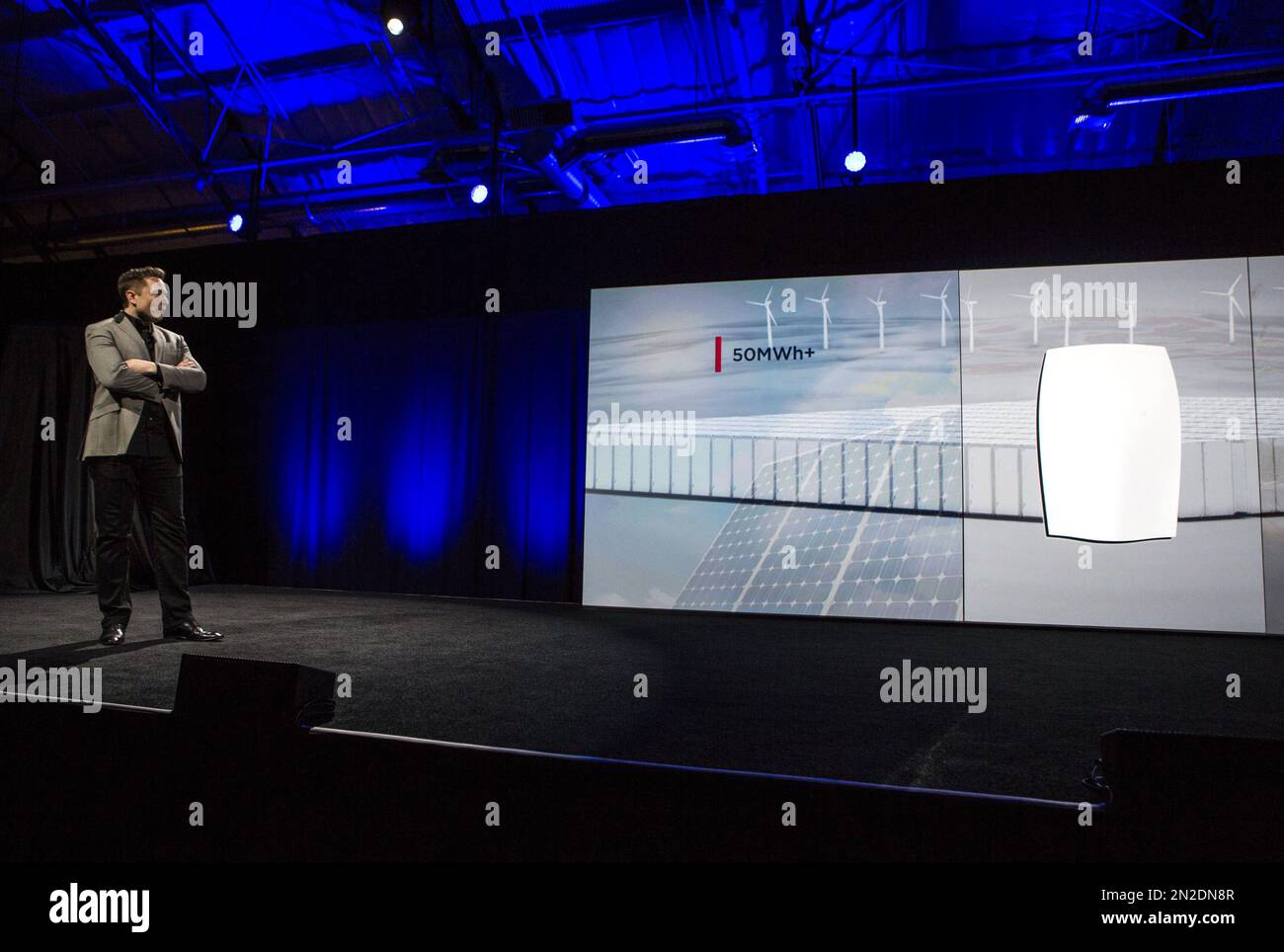 Tesla Motors CEO Elon Musk looks on as a graphic showing the newest ...