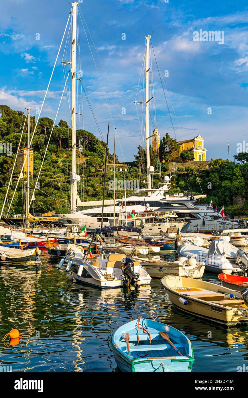 Boats and luxury yachts anchor in the harbour of Portofino, behind the ...